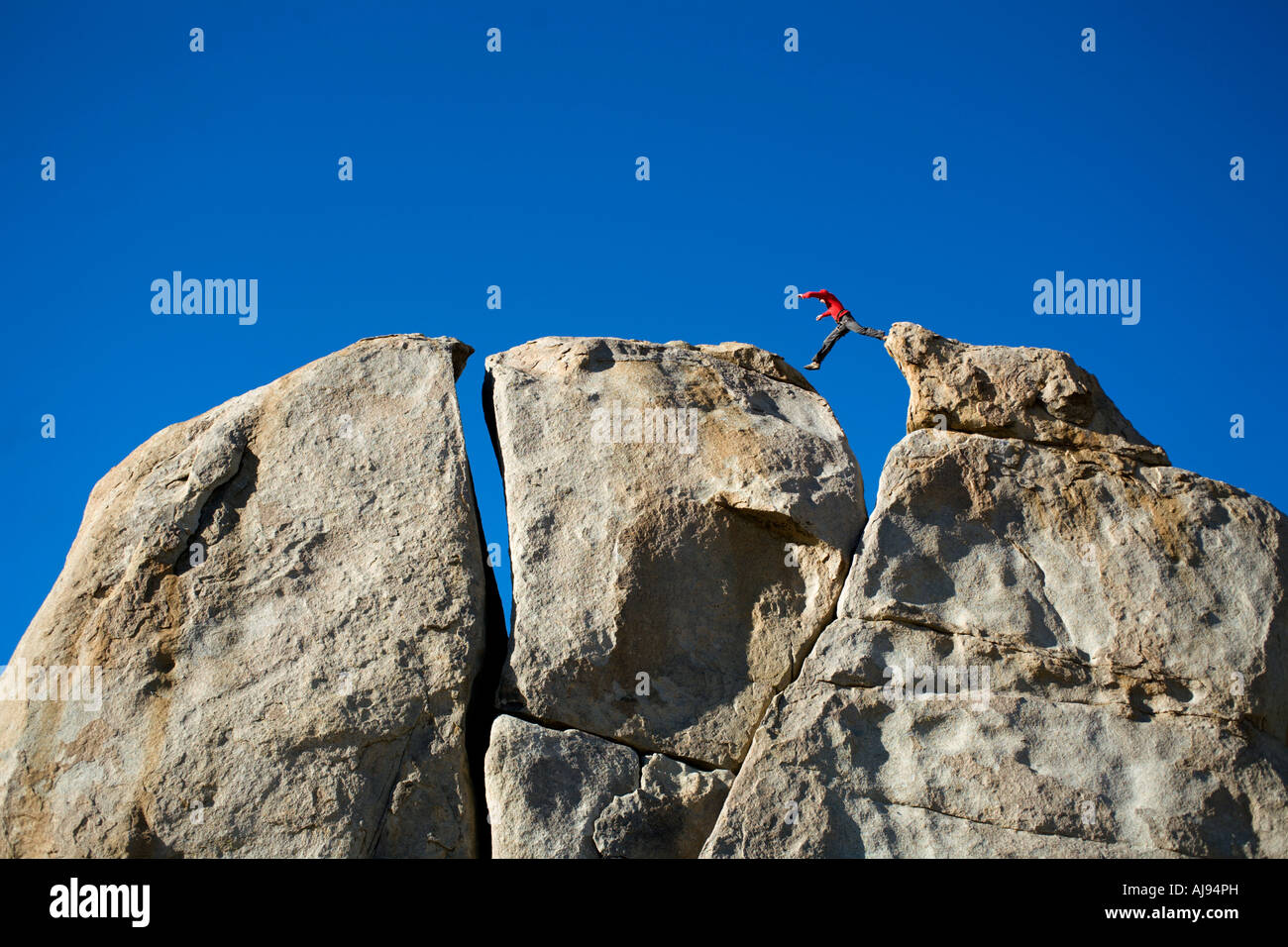Climber jumping across a gap Stock Photo - Alamy