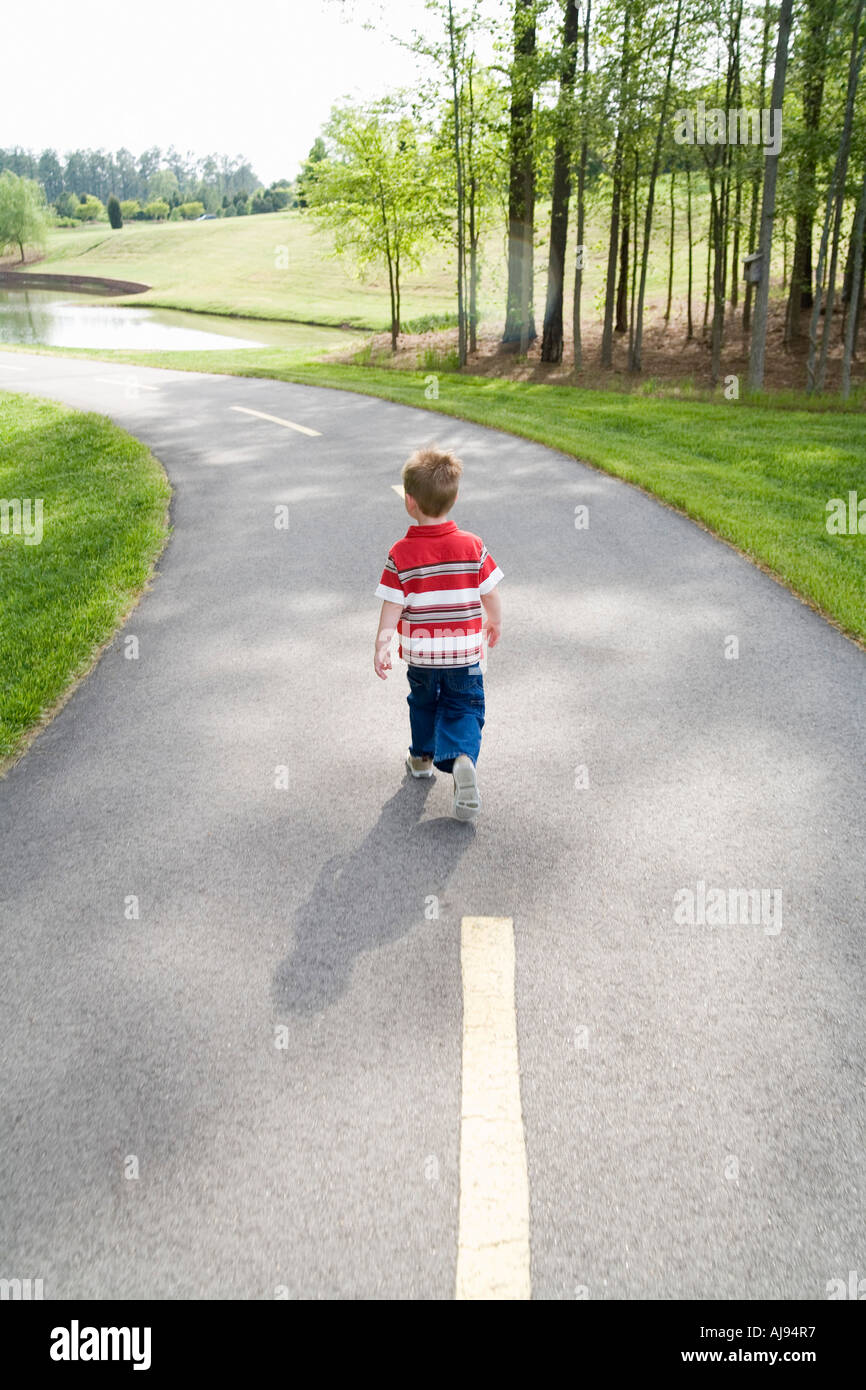 Young boy walking down path in park Stock Photo - Alamy