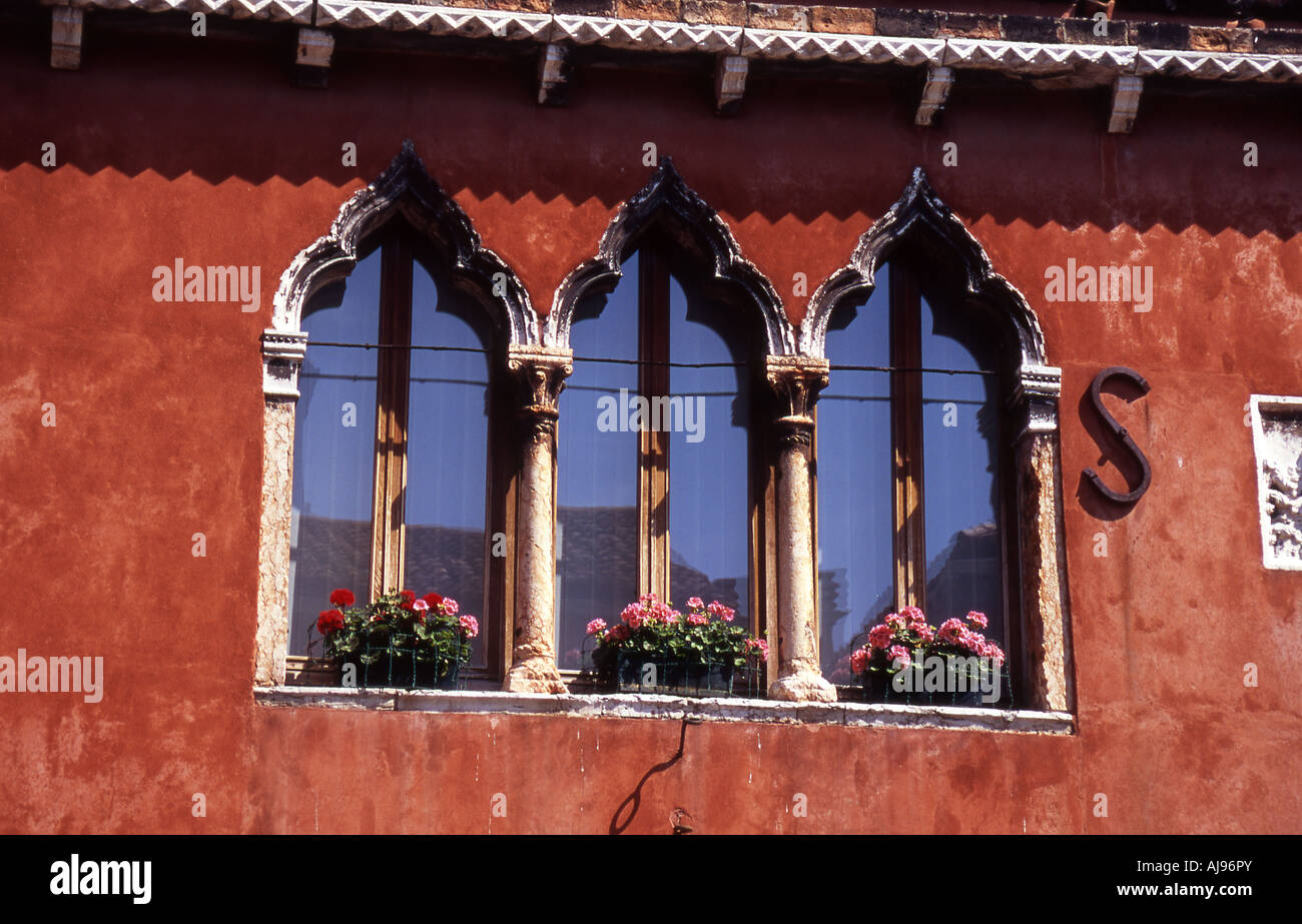 Moorish style windows on building with orange stucco in Murano Venice ...