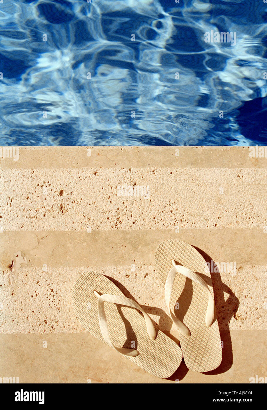 Flip flops at the edge of swimming pool Stock Photo - Alamy