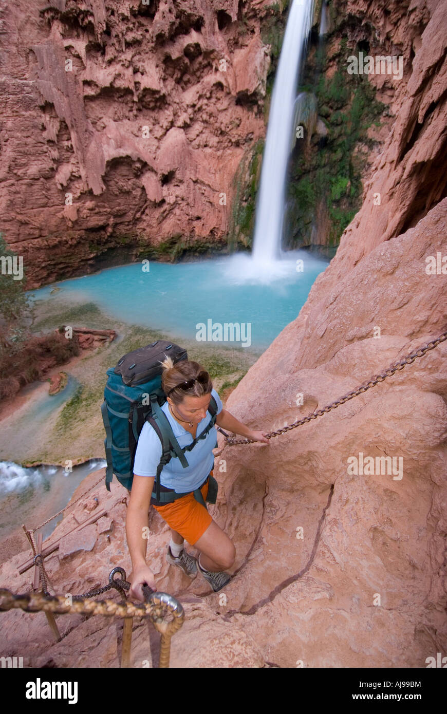Woman climbs stairs at waterfall Stock Photo - Alamy