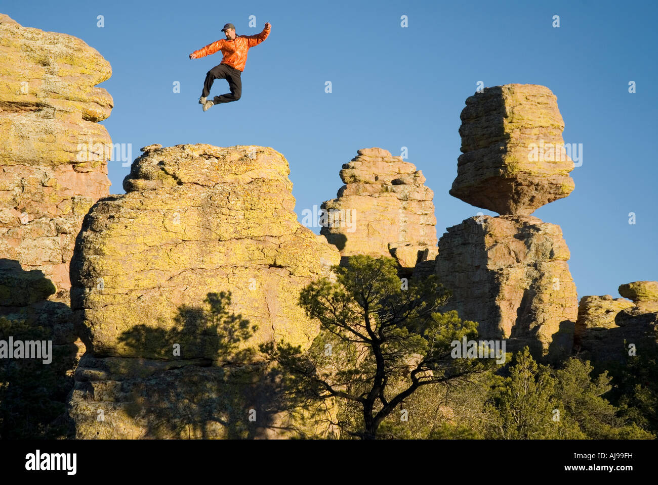 Man jumps on rock near Balanced Rock Stock Photo - Alamy