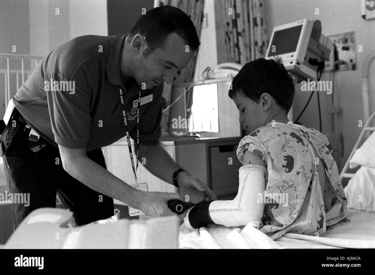 A pediatric nurse stting the plaster on the arm of a child patient ...