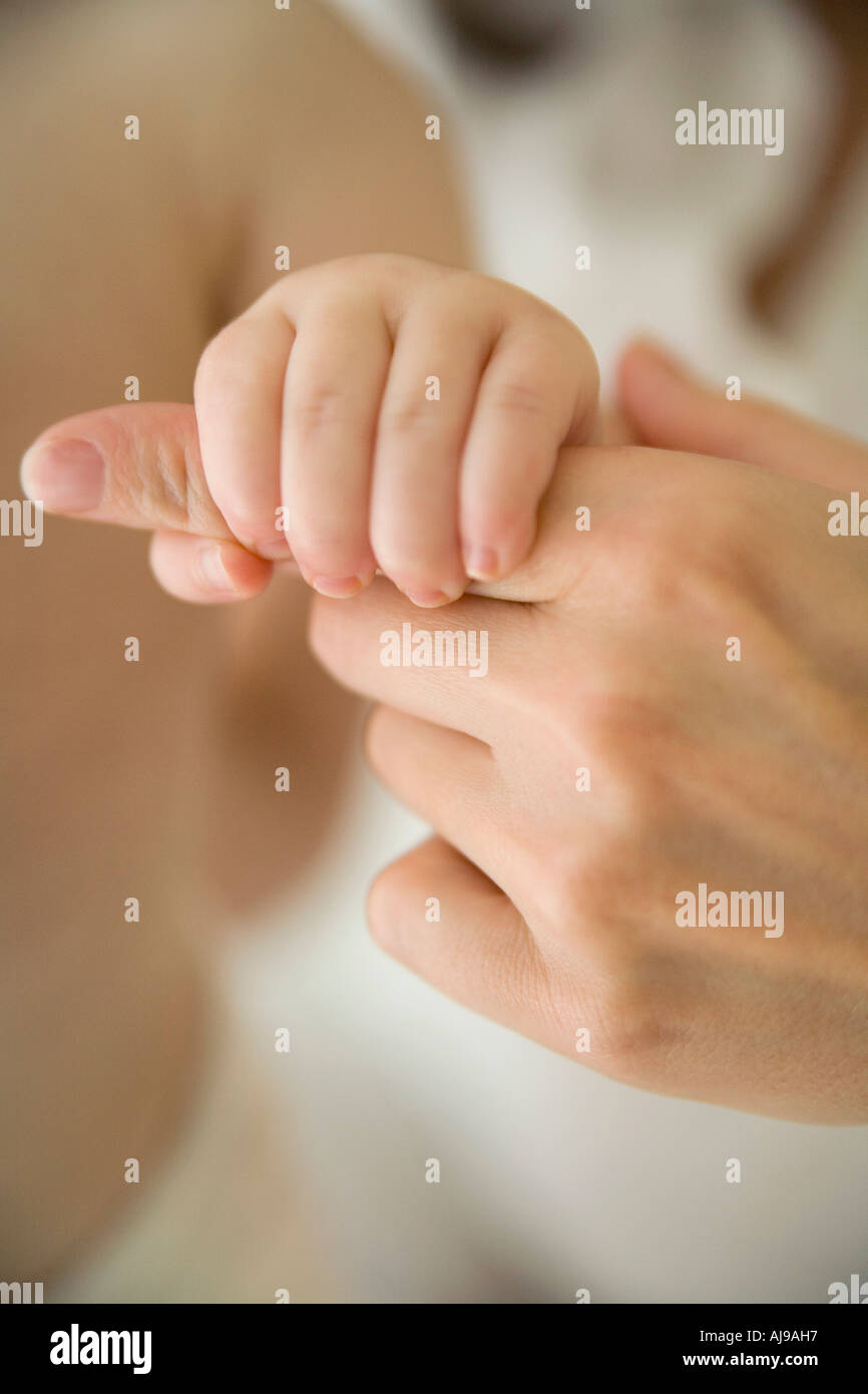 Baby gripping mother s finger Stock Photo - Alamy