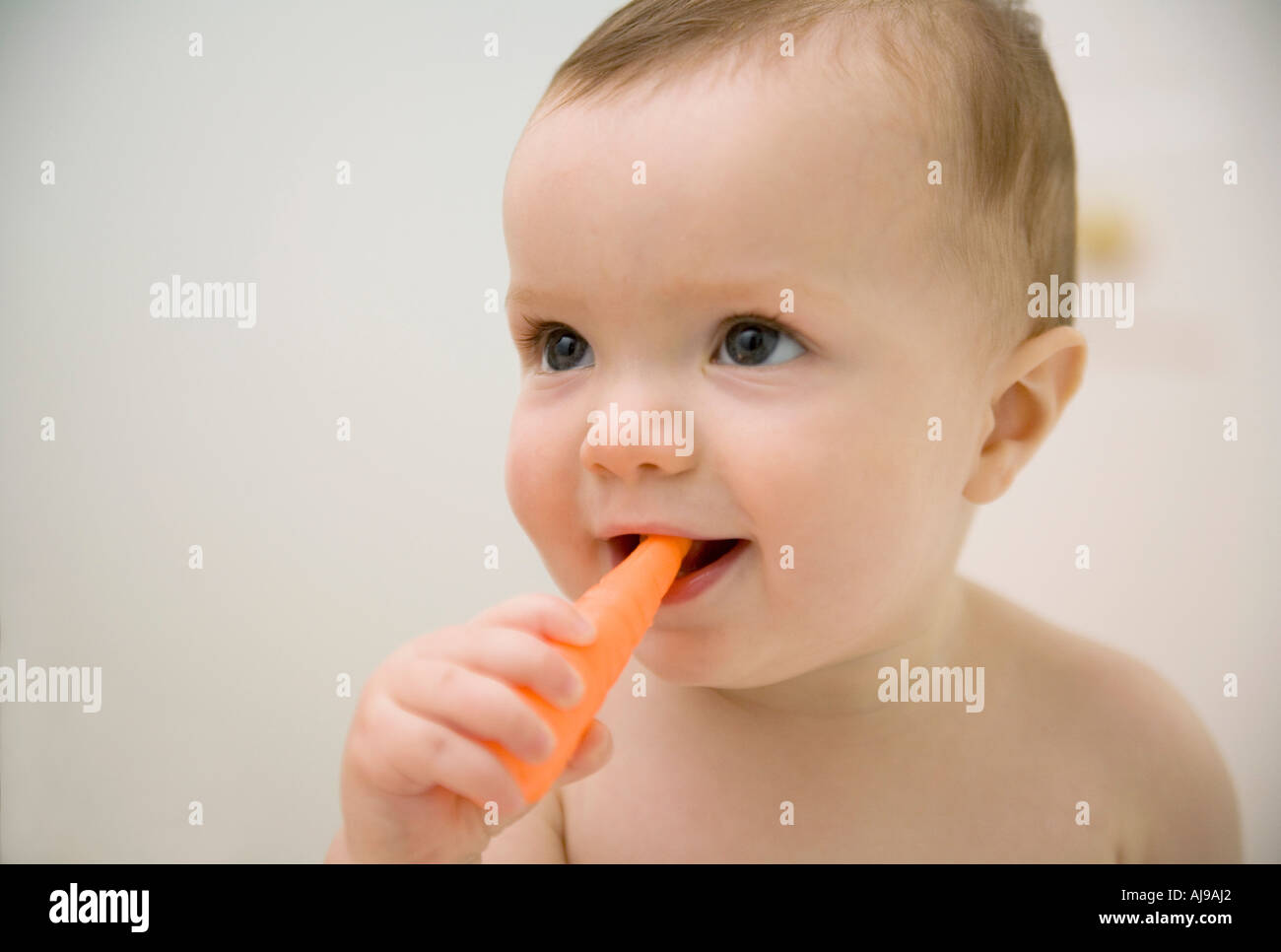Baby biting plastic carrot Stock Photo - Alamy