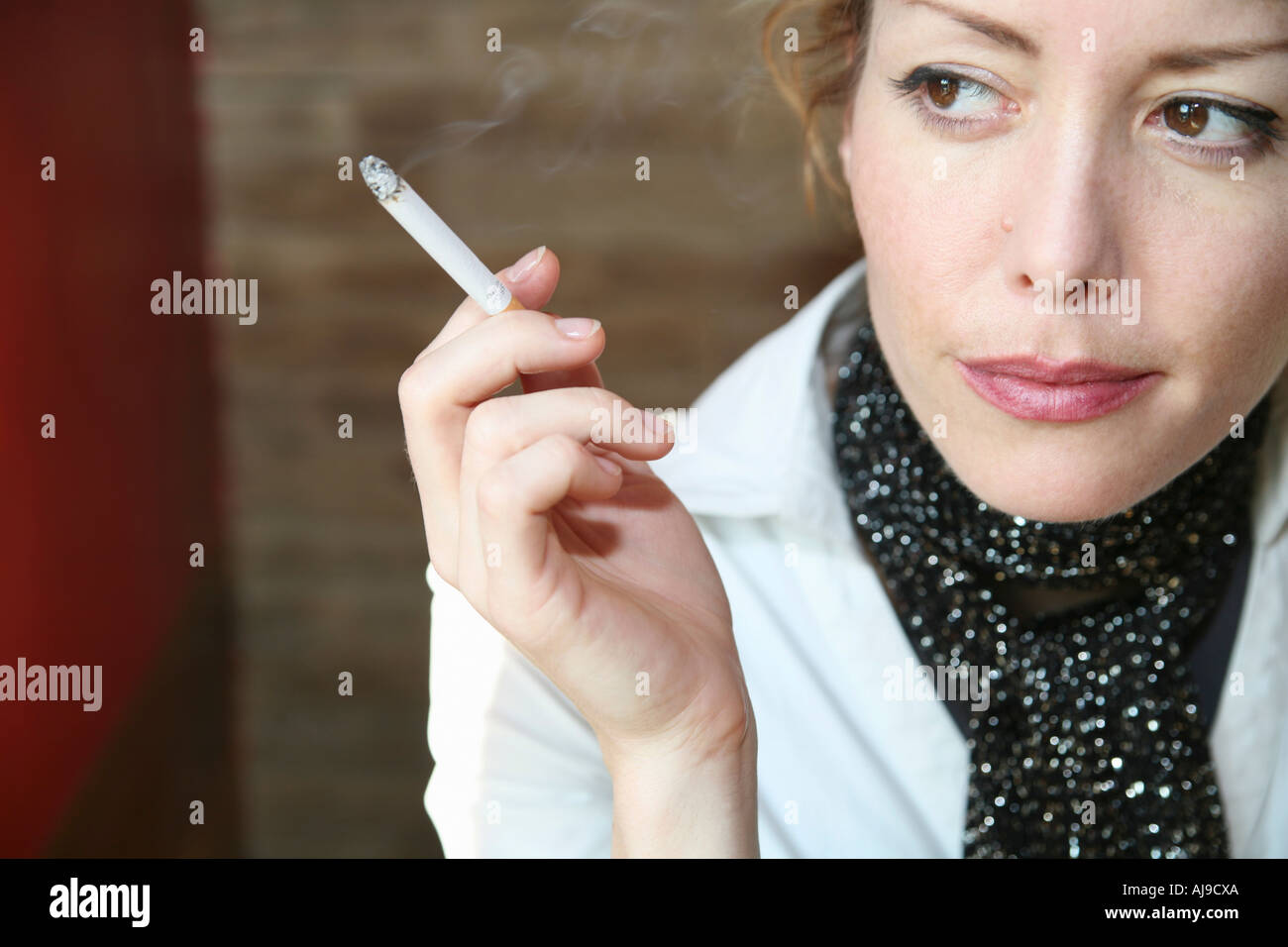 Woman sitting in cafe smoking a cigarette Stock Photo - Alamy