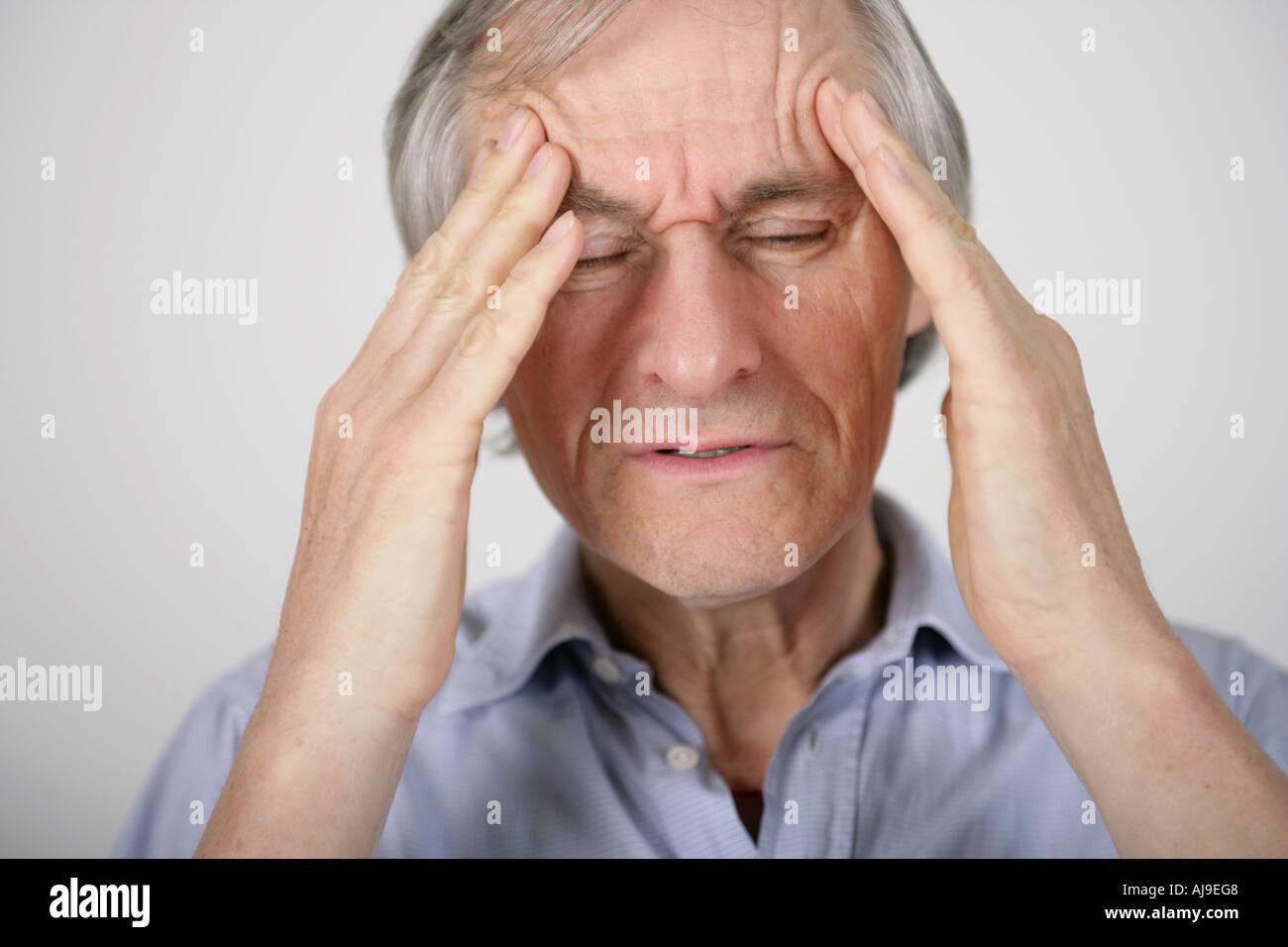 Senior man holding his head Stock Photo - Alamy