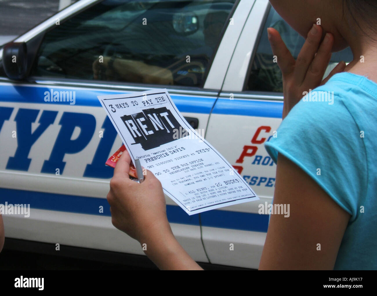 Girl reading letter next to NYPD police car Stock Photo - Alamy