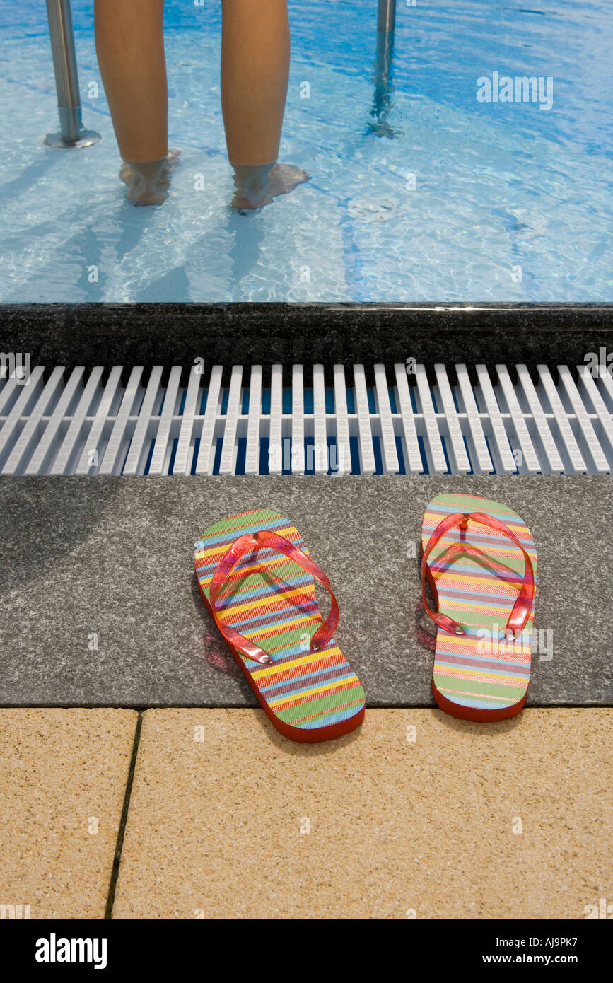 A pair of flip flops next to a swimming pool Stock Photo - Alamy