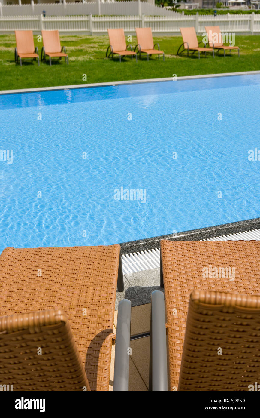 Lounge chairs around a swimming pool Stock Photo - Alamy