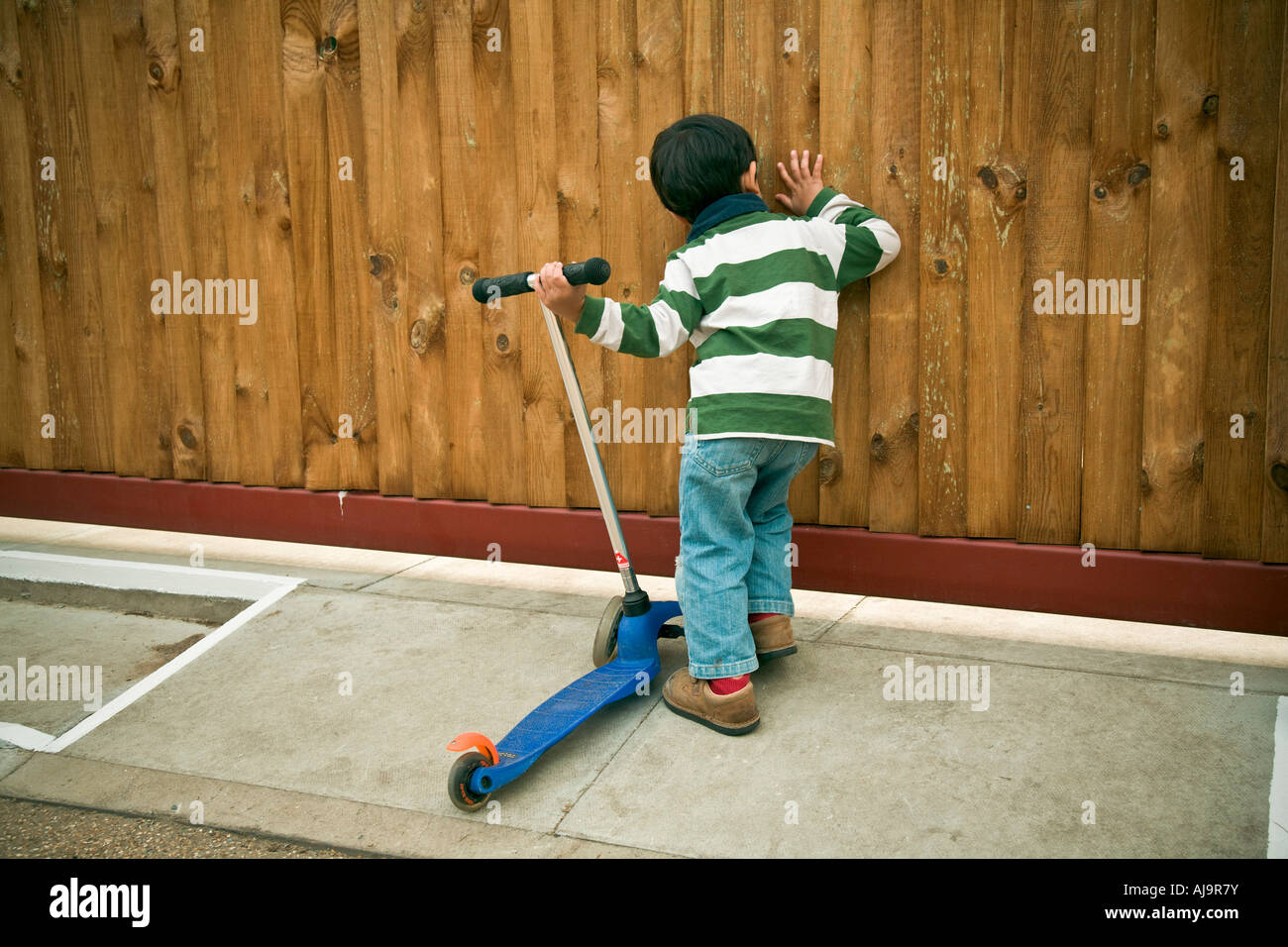 Boy Peeking Through Fence Stock Photo - Alamy