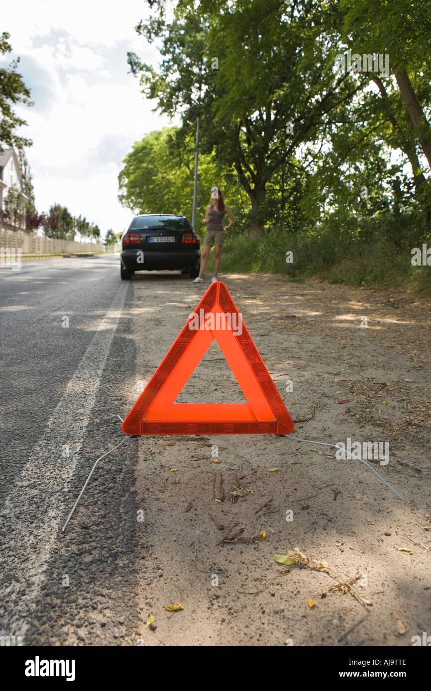A warning triangle behind a car on the side of a road Stock Photo - Alamy