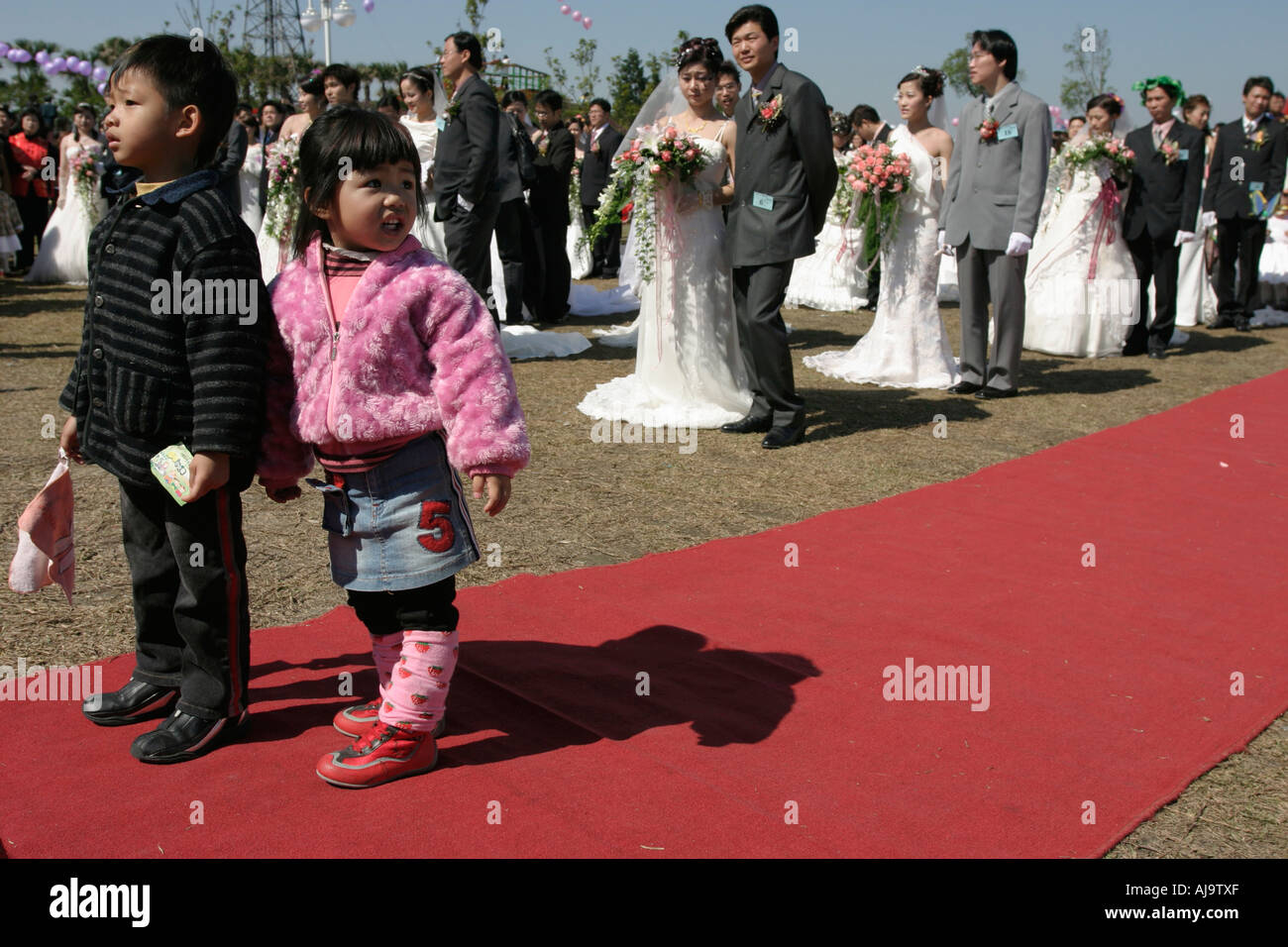 Boy and girl attending group wedding in Asia Stock Photo - Alamy