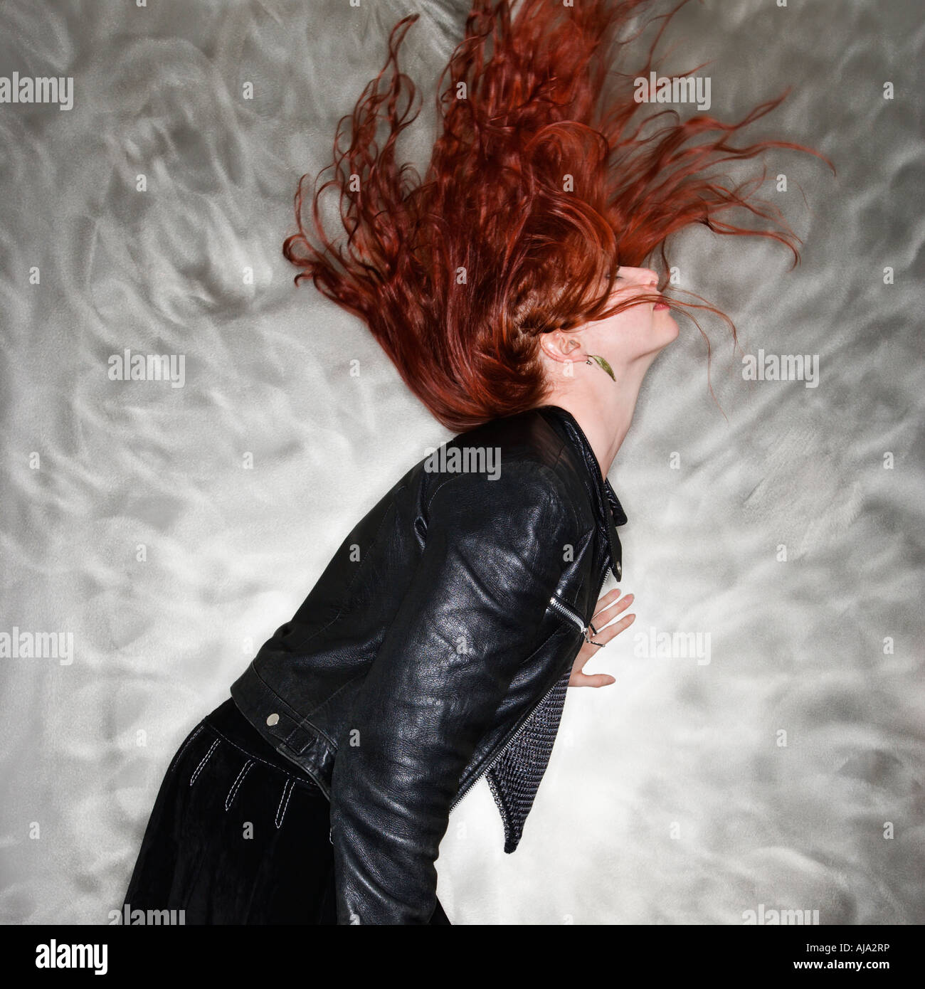 Side view of Caucasian young woman flipping hair into air Stock Photo ...
