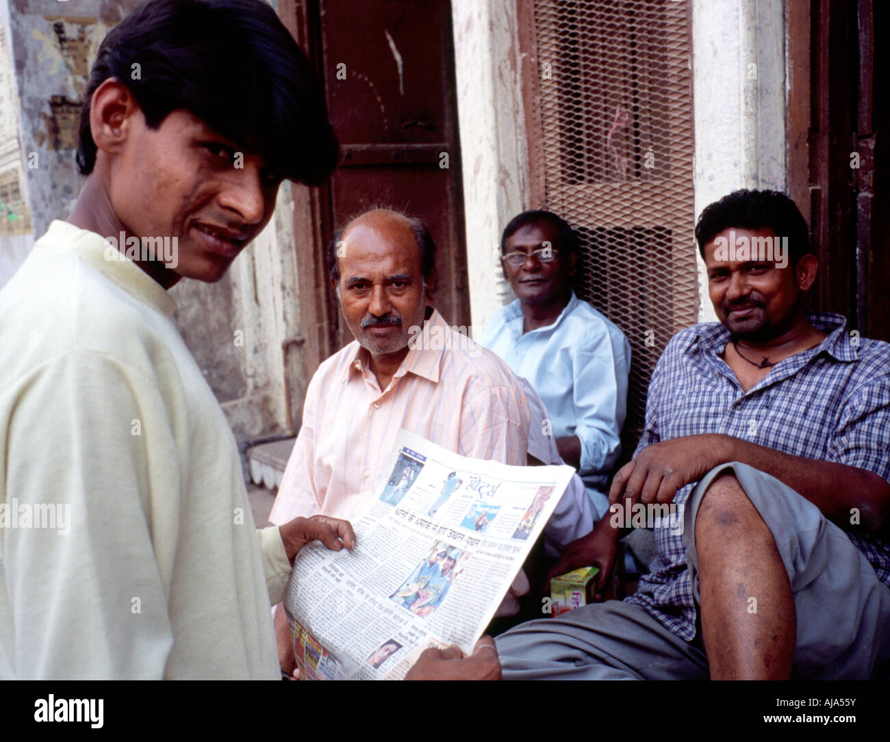 Indian man reading newspaper to friends hi-res stock photography and ...