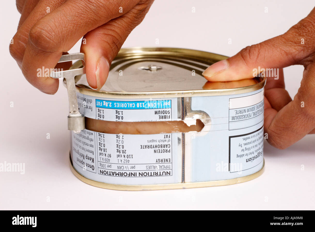 Woman opening a can of pork with a key Stock Photo - Alamy