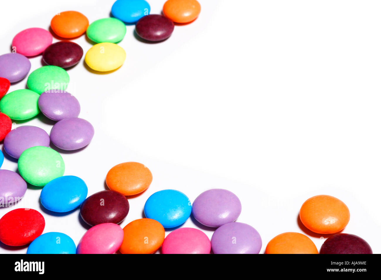 Colorful candy arranged in a pattern on a white background with copy ...