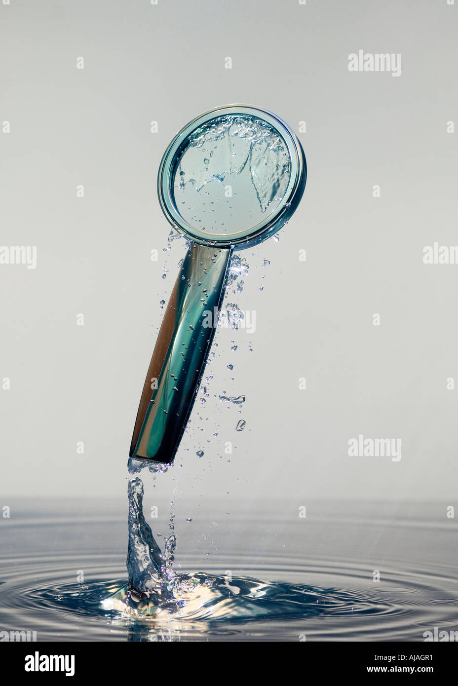 Magnifying glass falling into water Stock Photo - Alamy