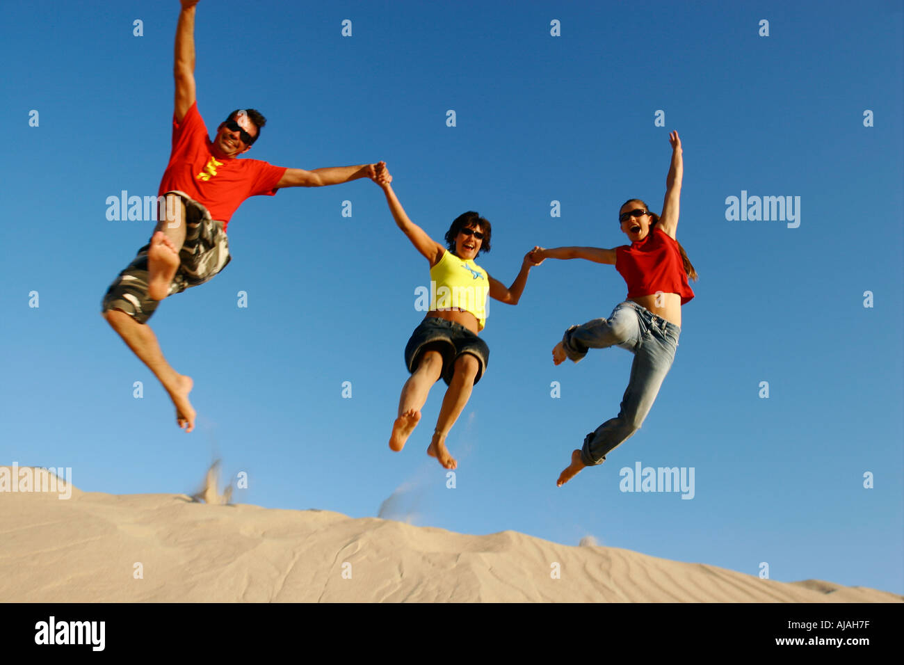 Jumping over the edge of a sand dune Stock Photo - Alamy
