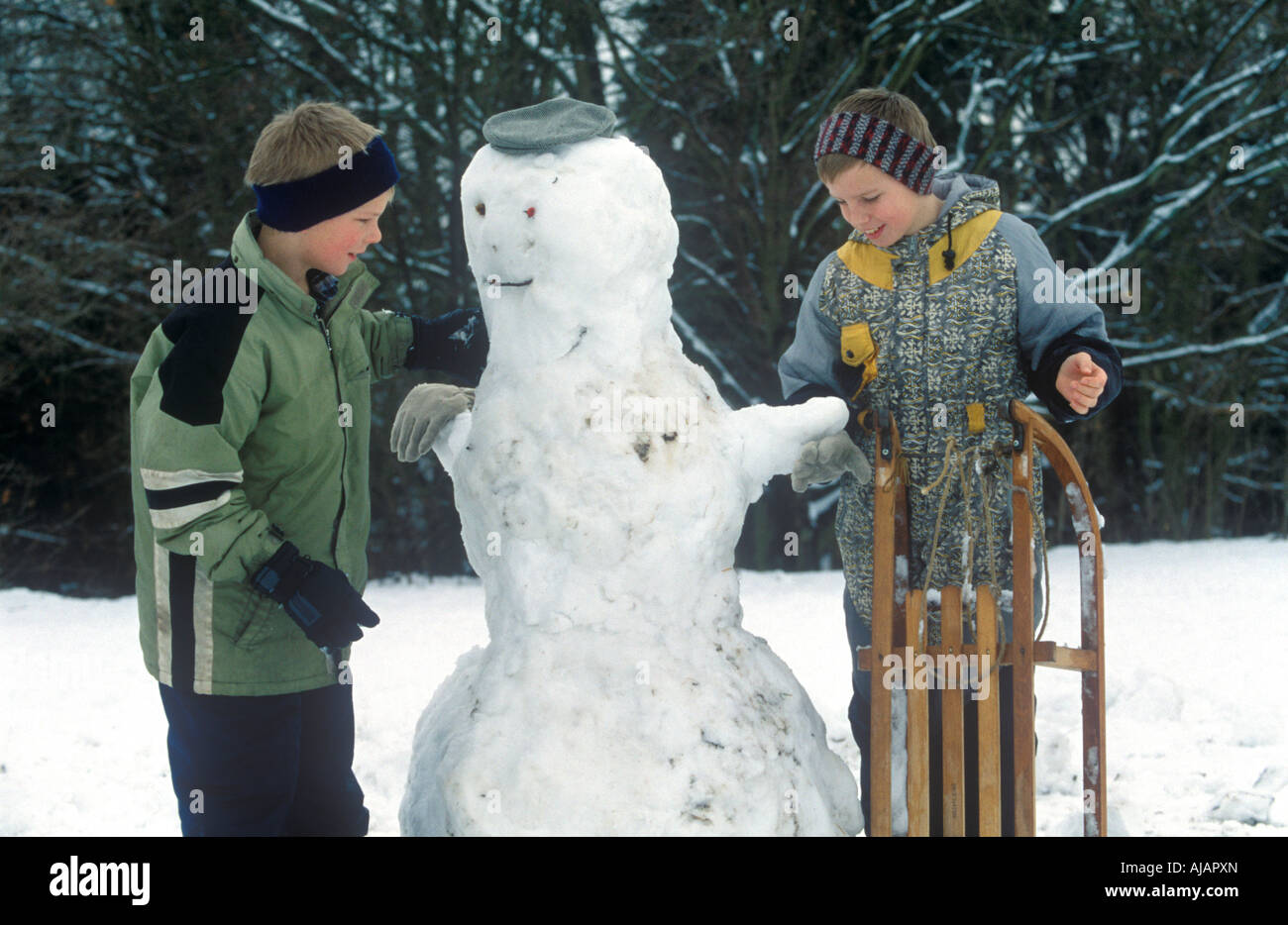two young boys building a snowman Stock Photo - Alamy