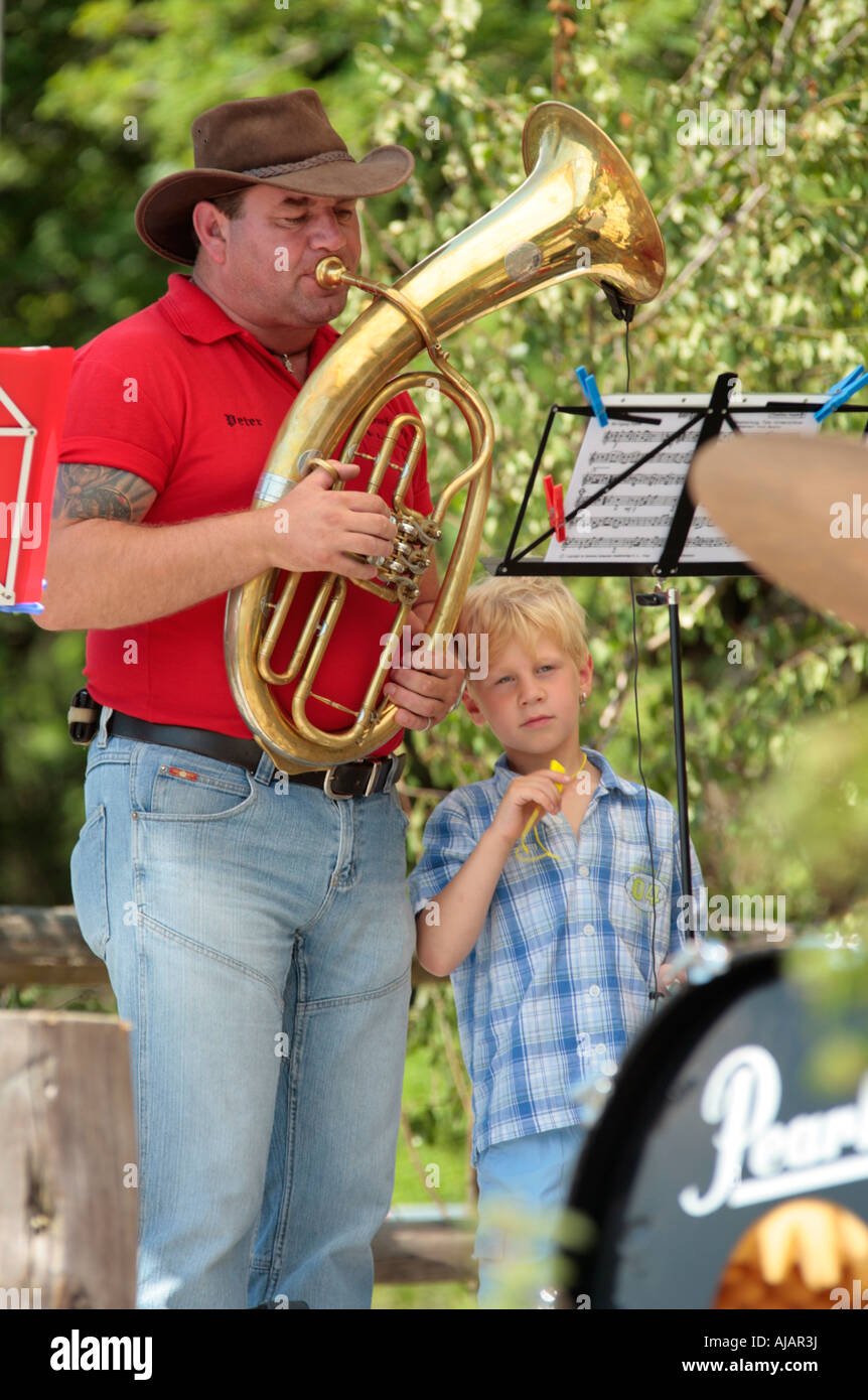 a father sounding a horn with his young son standing beside him Stock ...