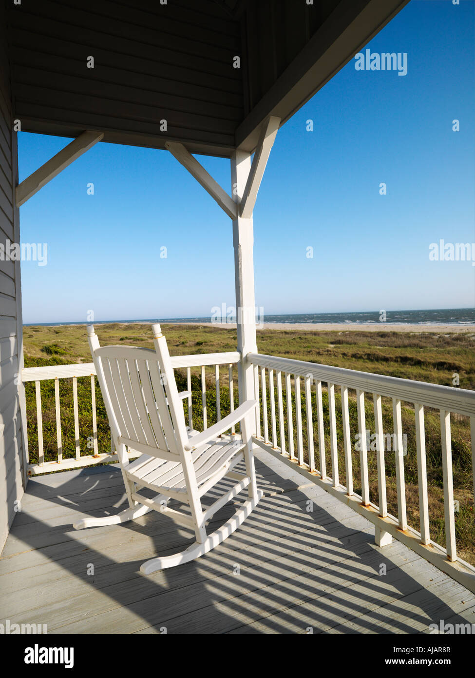 Rocking chair on porch with railing overlooking beach at Bald Head ...