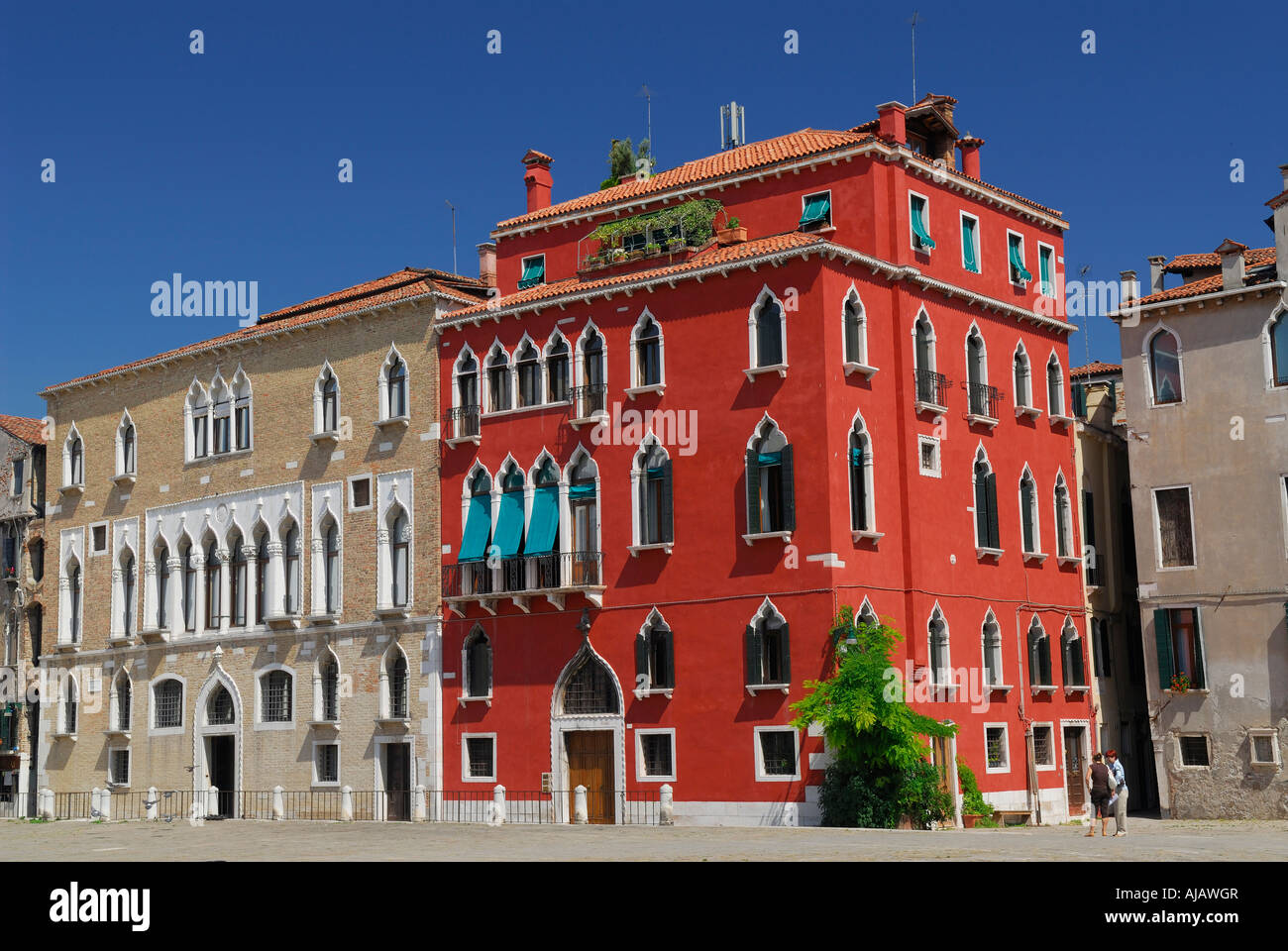 Freshly stuccoed red apartment building in Venice Italy with blue sky ...