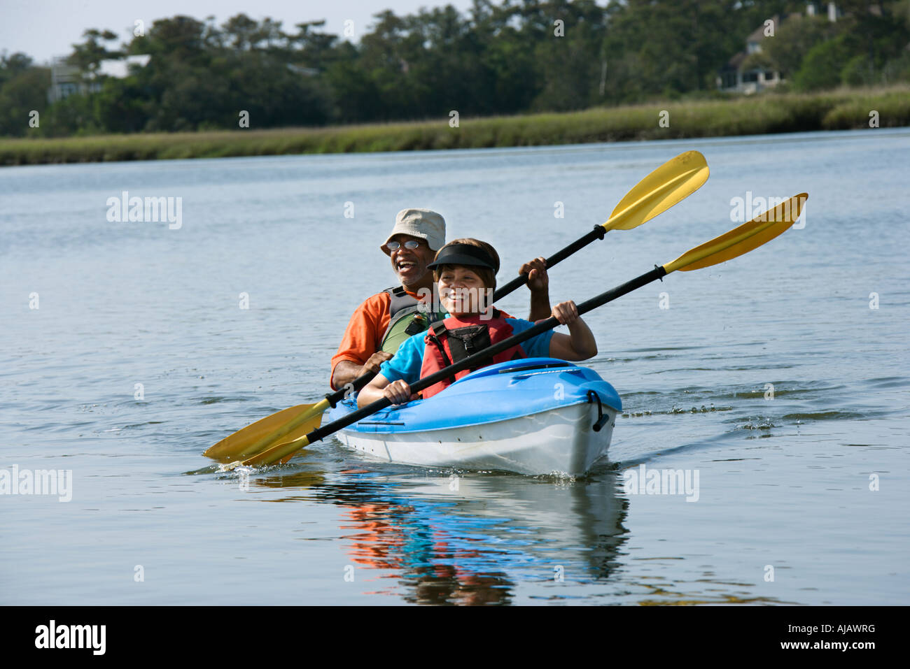 African American middle aged couple smiling and paddling kayak Stock ...