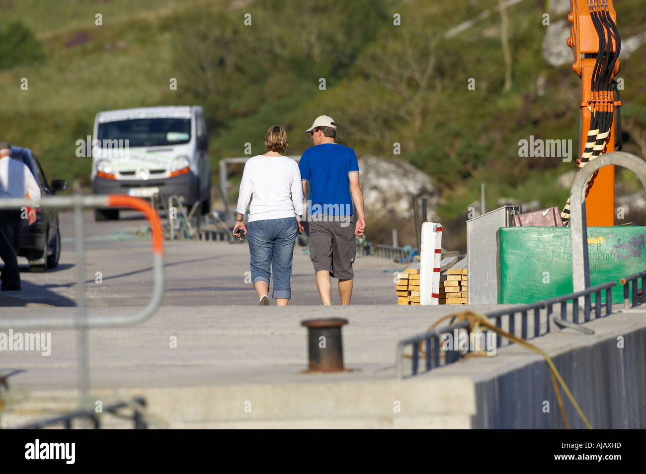 couple walking hand in hand along quayside at bunbeg harbour gweedore ...
