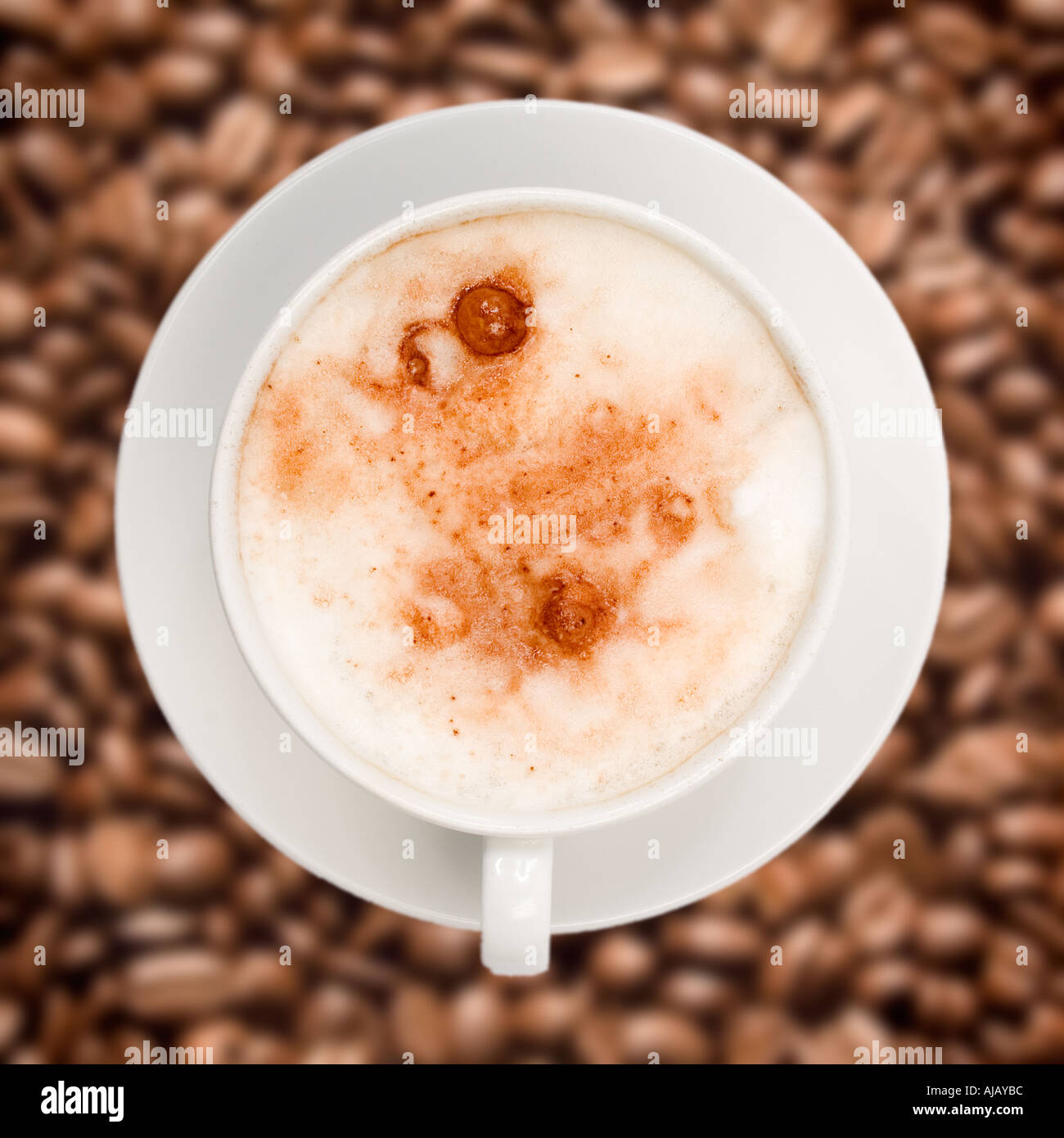A cup of frothy chocolate topped cappuccino coffee superimposed on a ...
