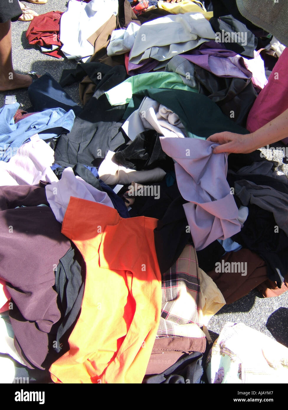 people rummaging through pile of old clothes Stock Photo - Alamy
