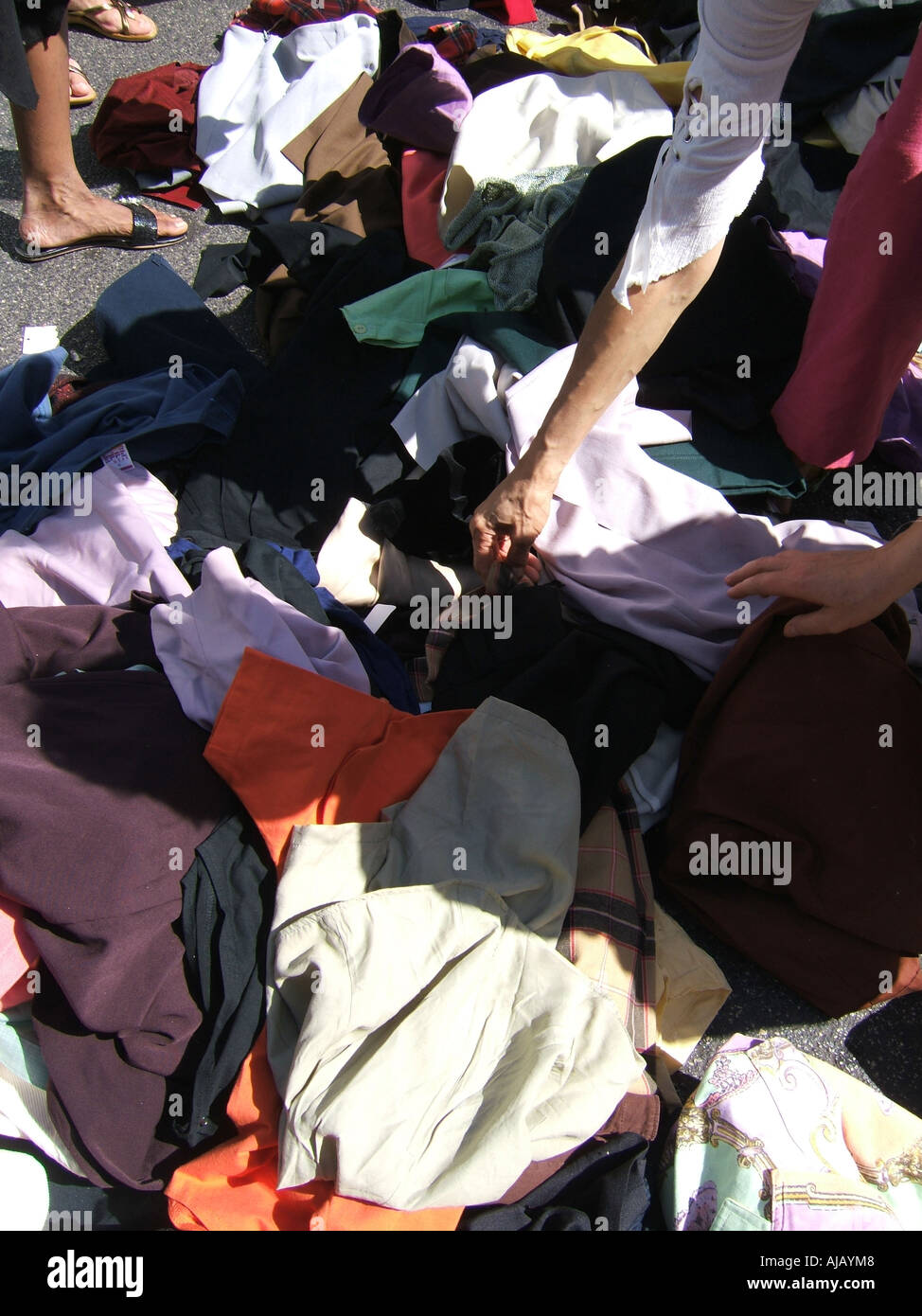 people rummaging through pile of old clothes Stock Photo - Alamy