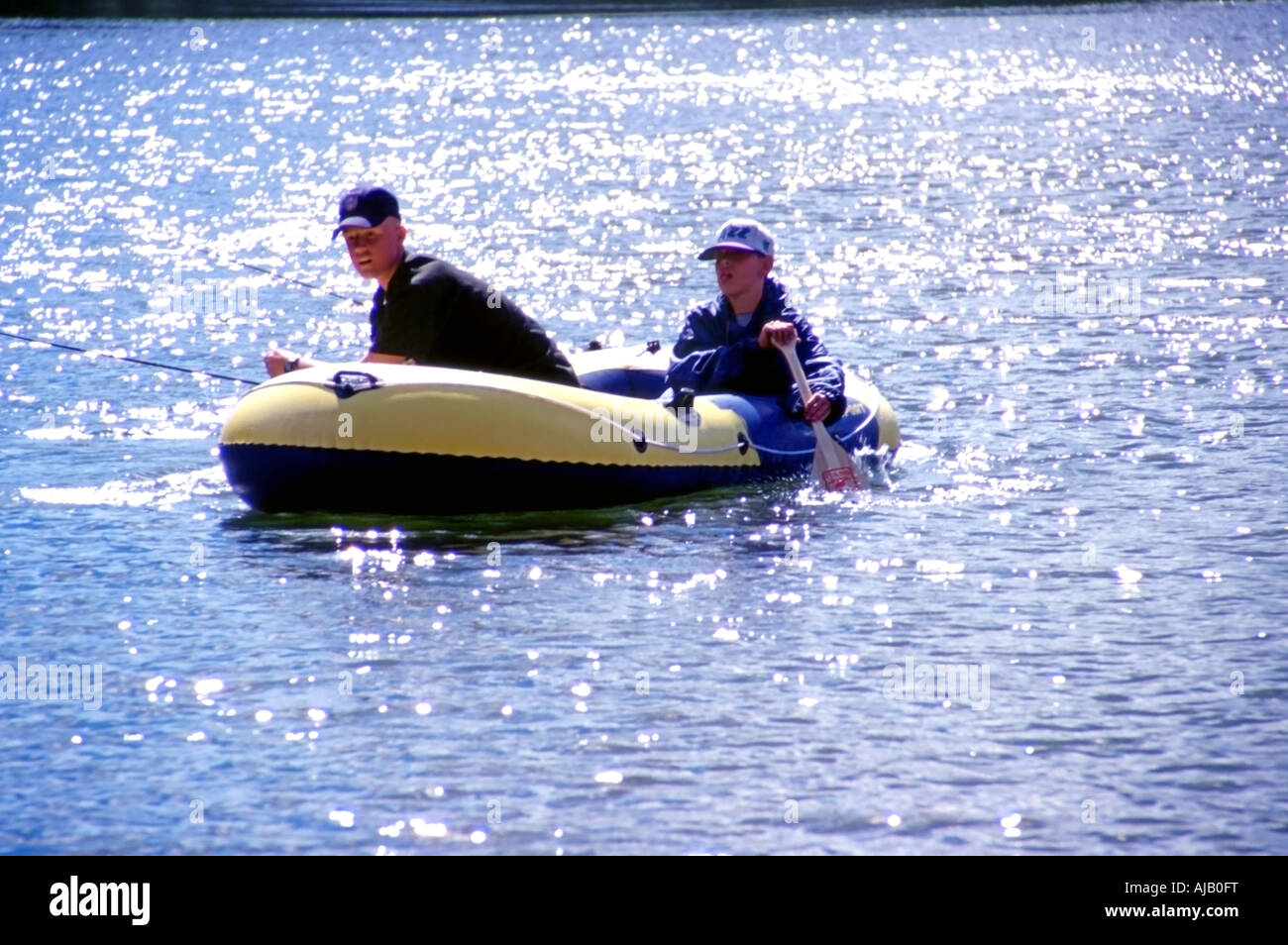Two teenage boys in a raft out on a mountain lake in Utah, USA. They're ...