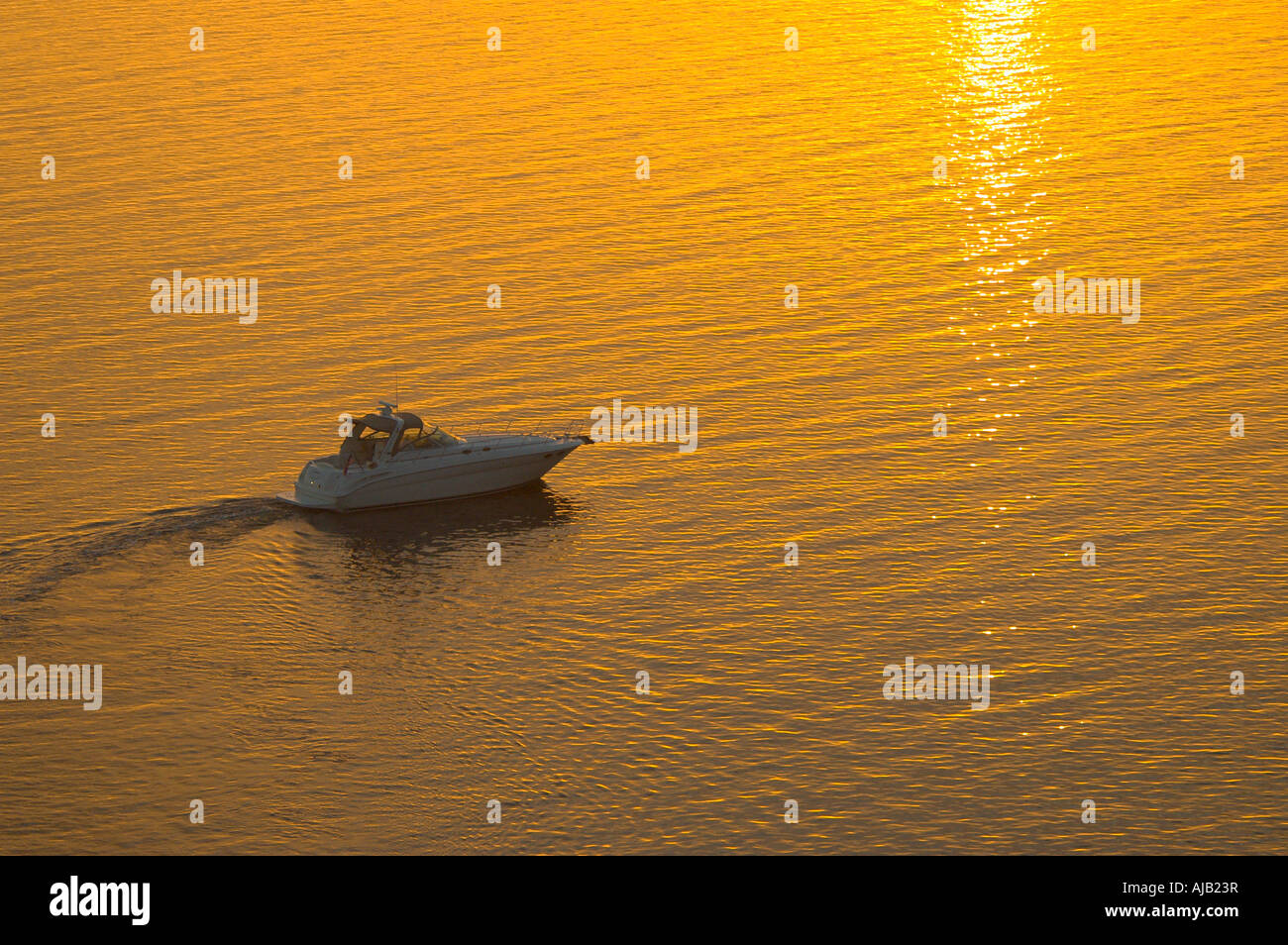 Boating inboard power outboard motor boat cruises sunset in calm flat ...