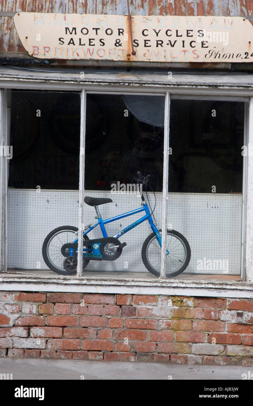 Brand new bicycles on show in neglected shop window of bike shop ...