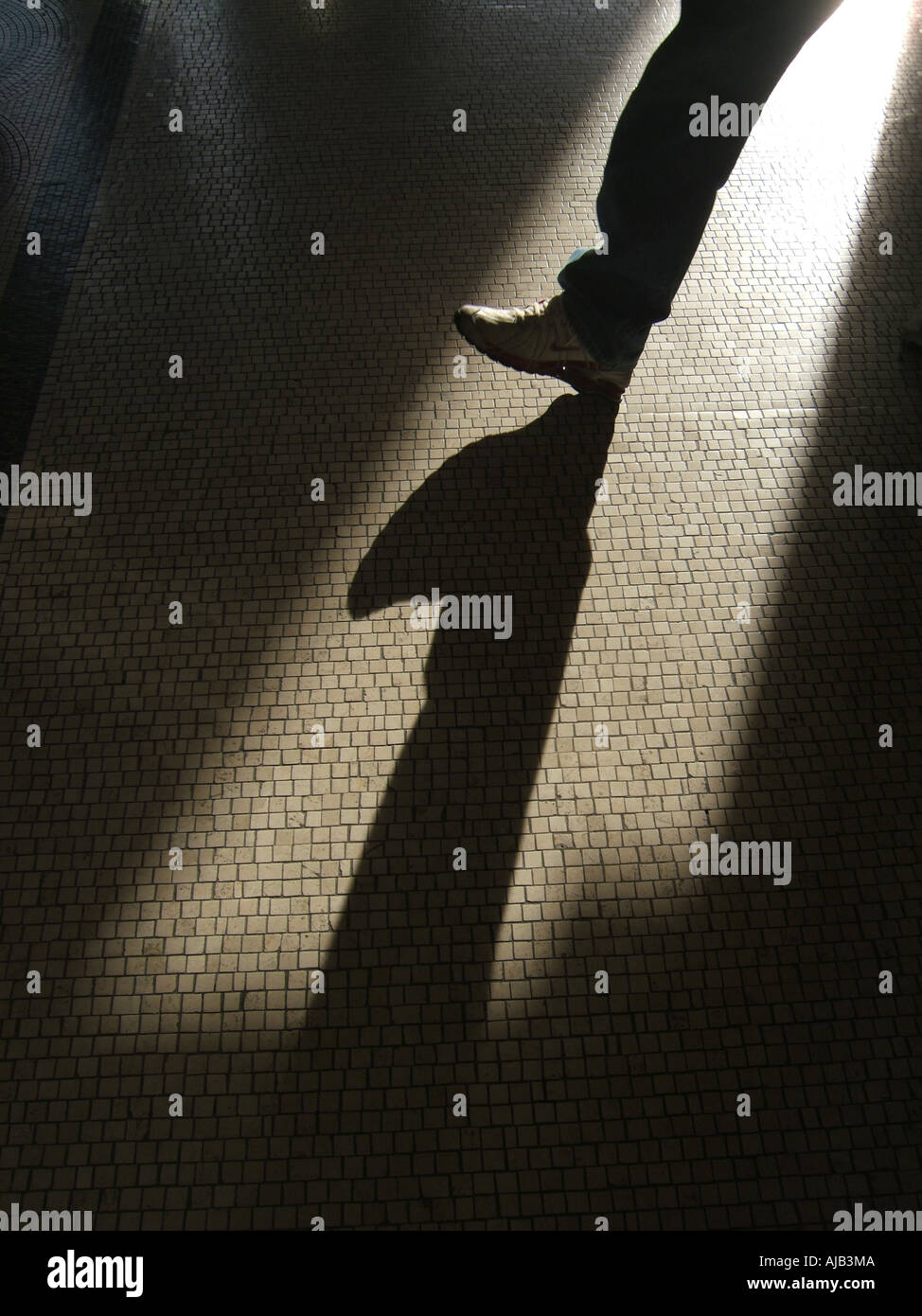person walking through beam of light Stock Photo - Alamy
