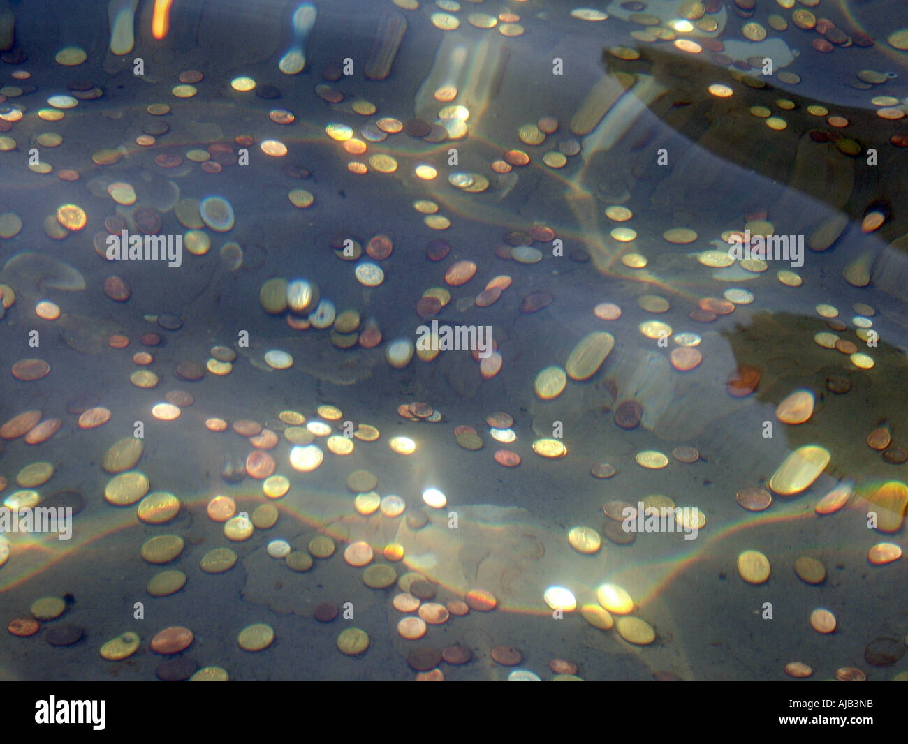 lots of coins in a wishing well Stock Photo - Alamy