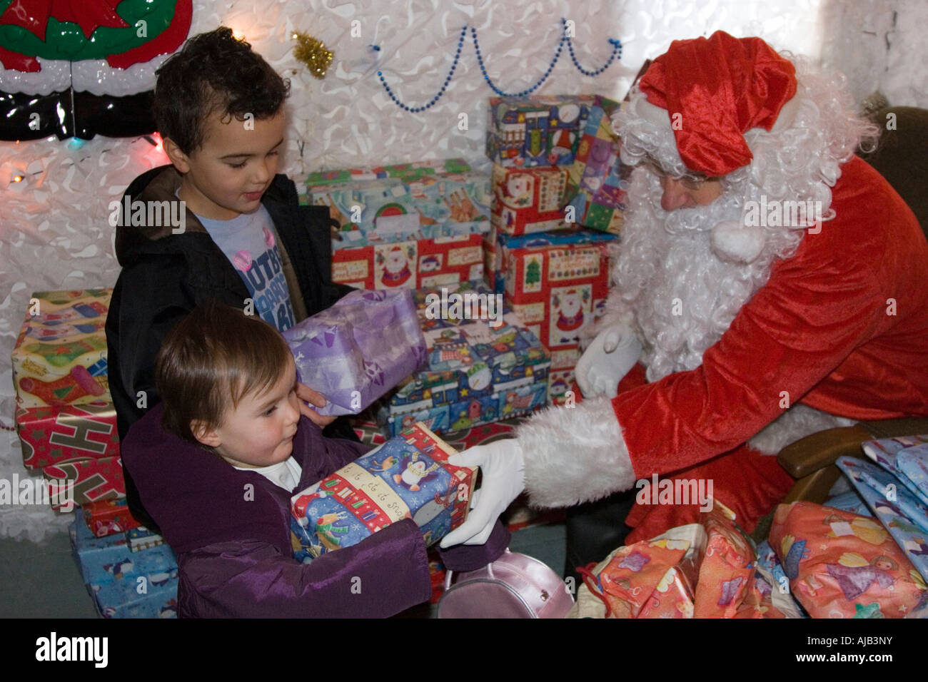 Brother and sister meeting Father Christmas and receiving Christmas ...