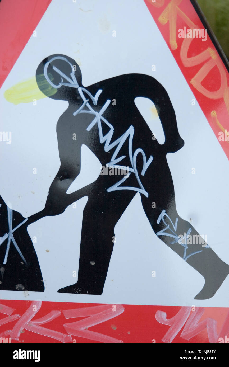 Men at work road sign with graffiti tags scrawled by mindless vandals ...