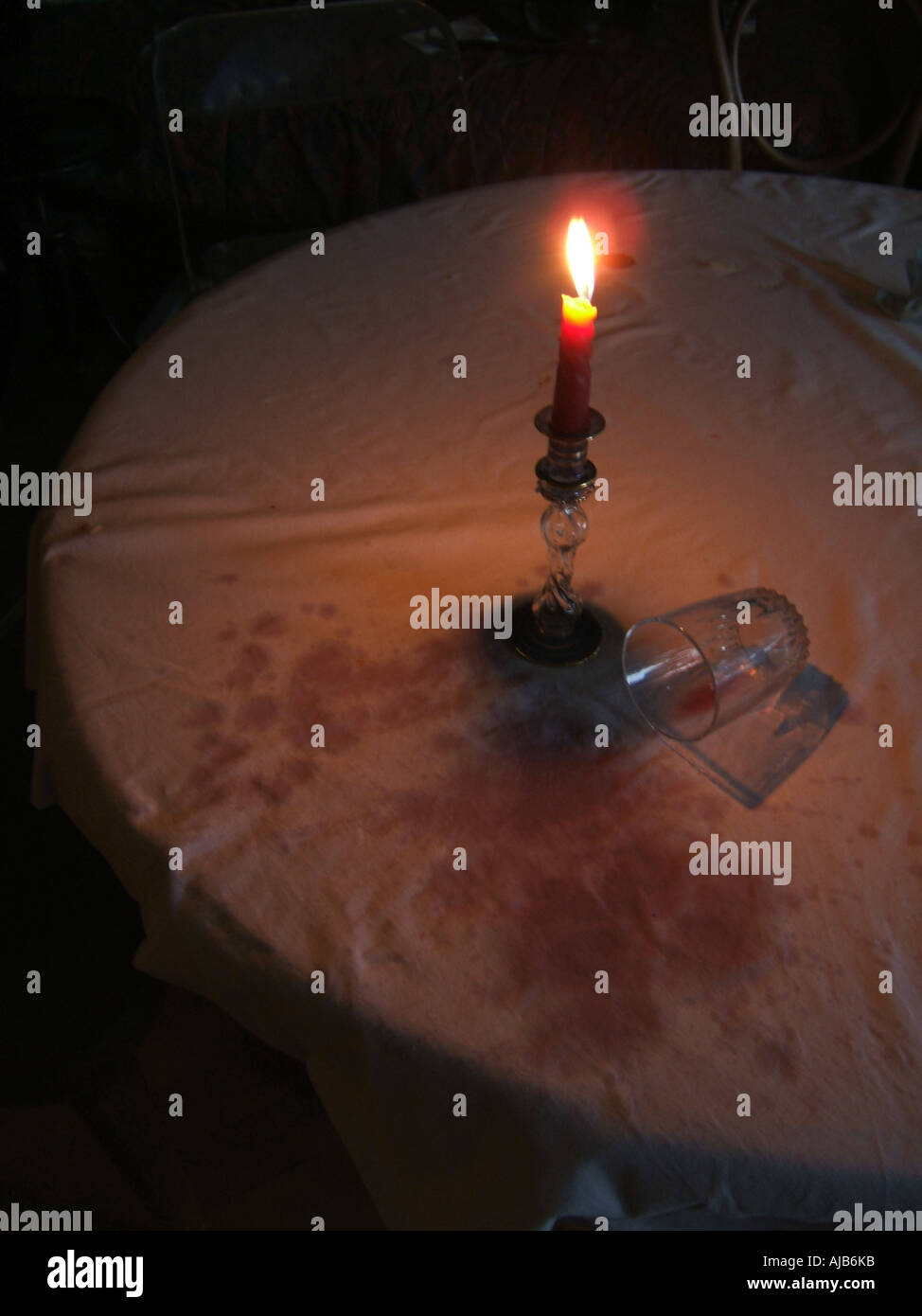 candle and spilt glass on dirty round table at night Stock Photo - Alamy