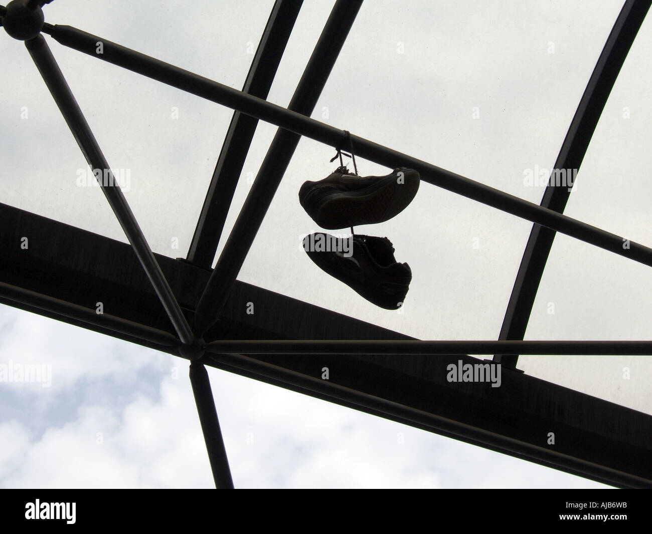 pair of shoes hanging from high structure with dark sky Stock Photo - Alamy