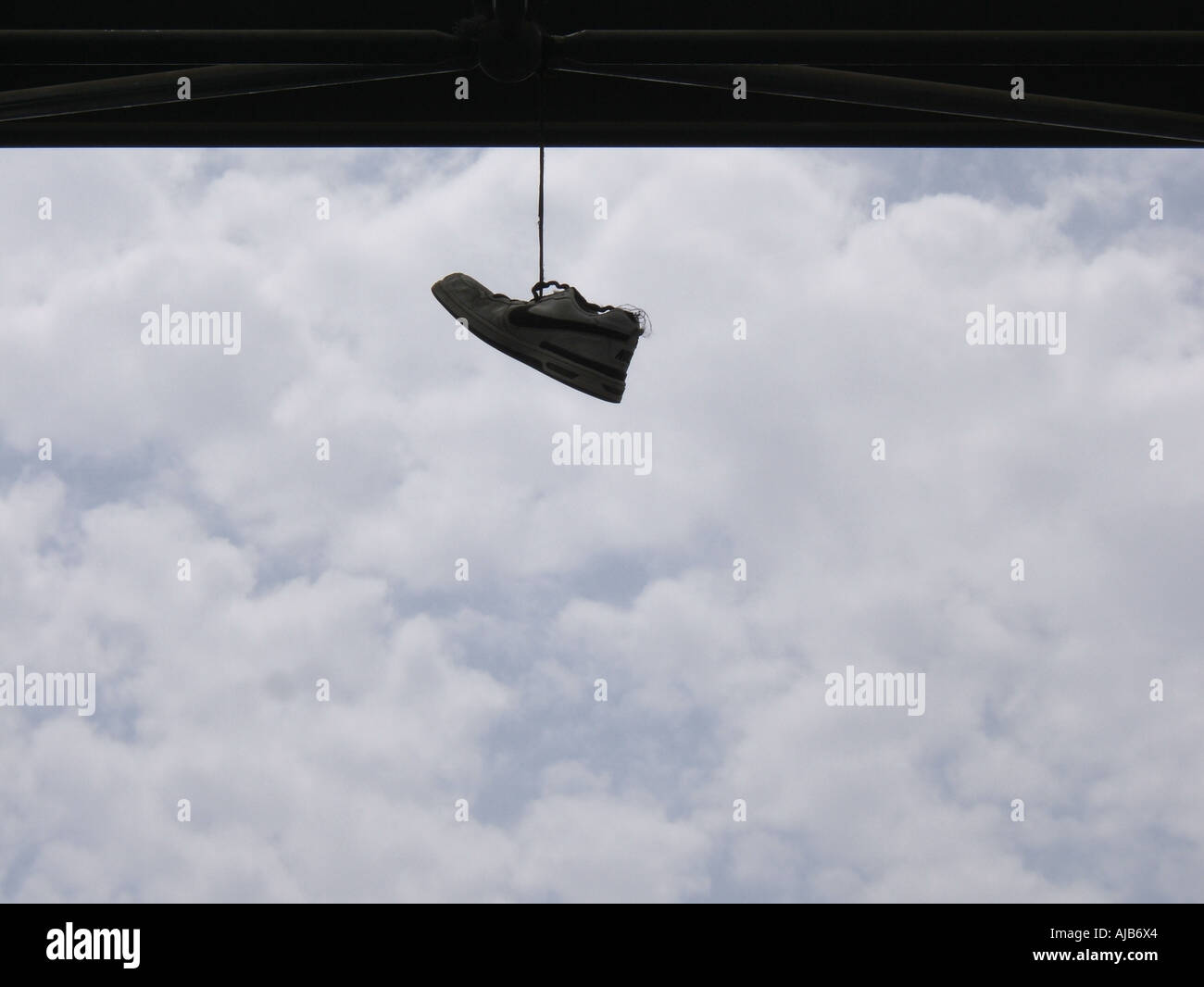 shoe hanging from high structure with dark sky Stock Photo - Alamy