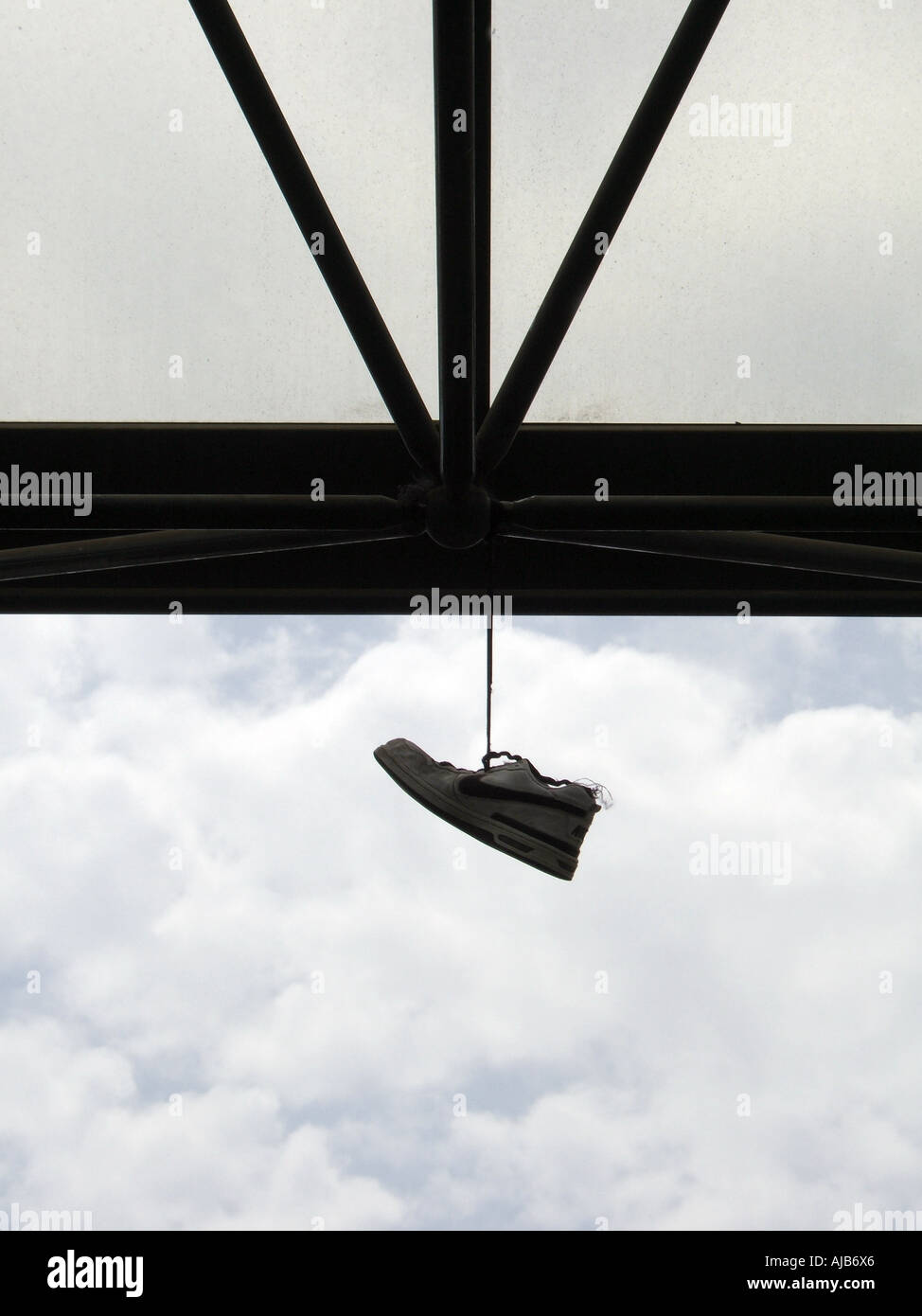 shoe hanging from high structure with dark sky Stock Photo - Alamy