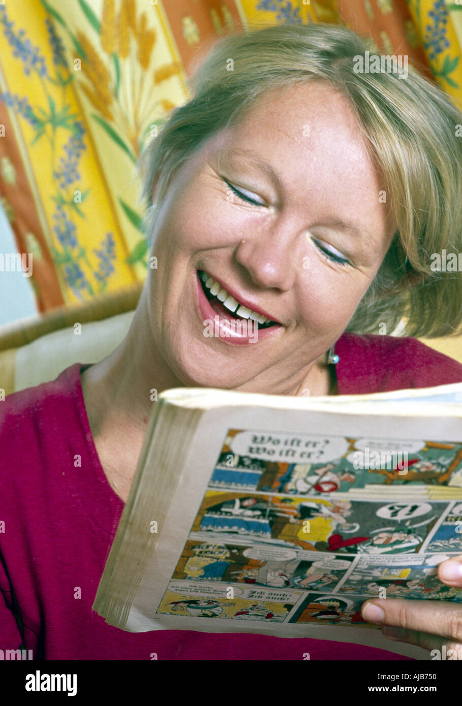 woman laughing and reading a comic magazine Stock Photo - Alamy