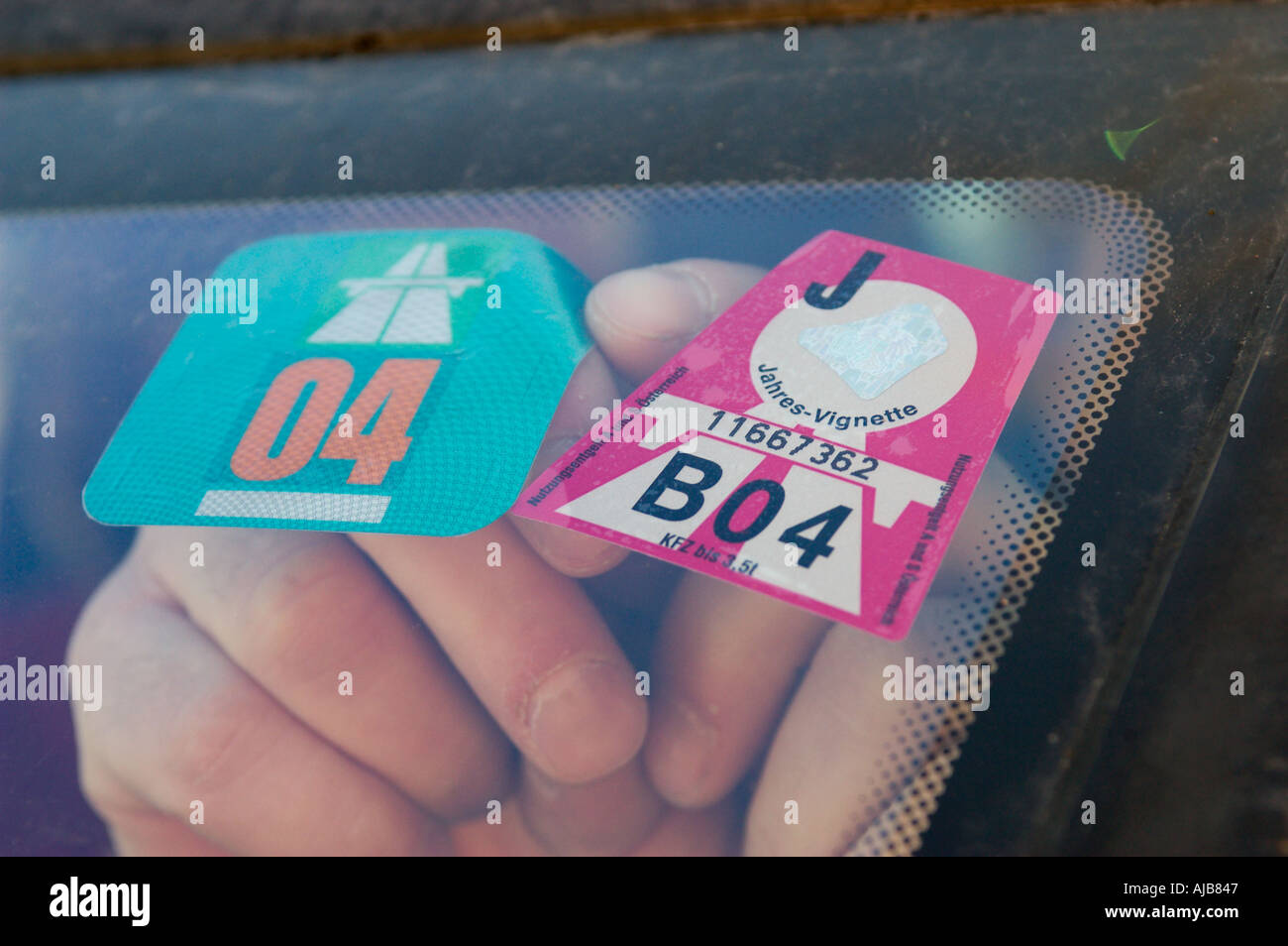 Motorist sticking labels for motorway toll in Switzerland and Austria ...