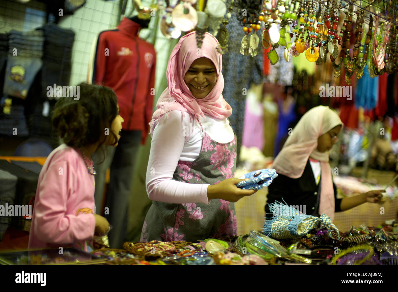 Muslim women and young girl looking at decorations on display night ...