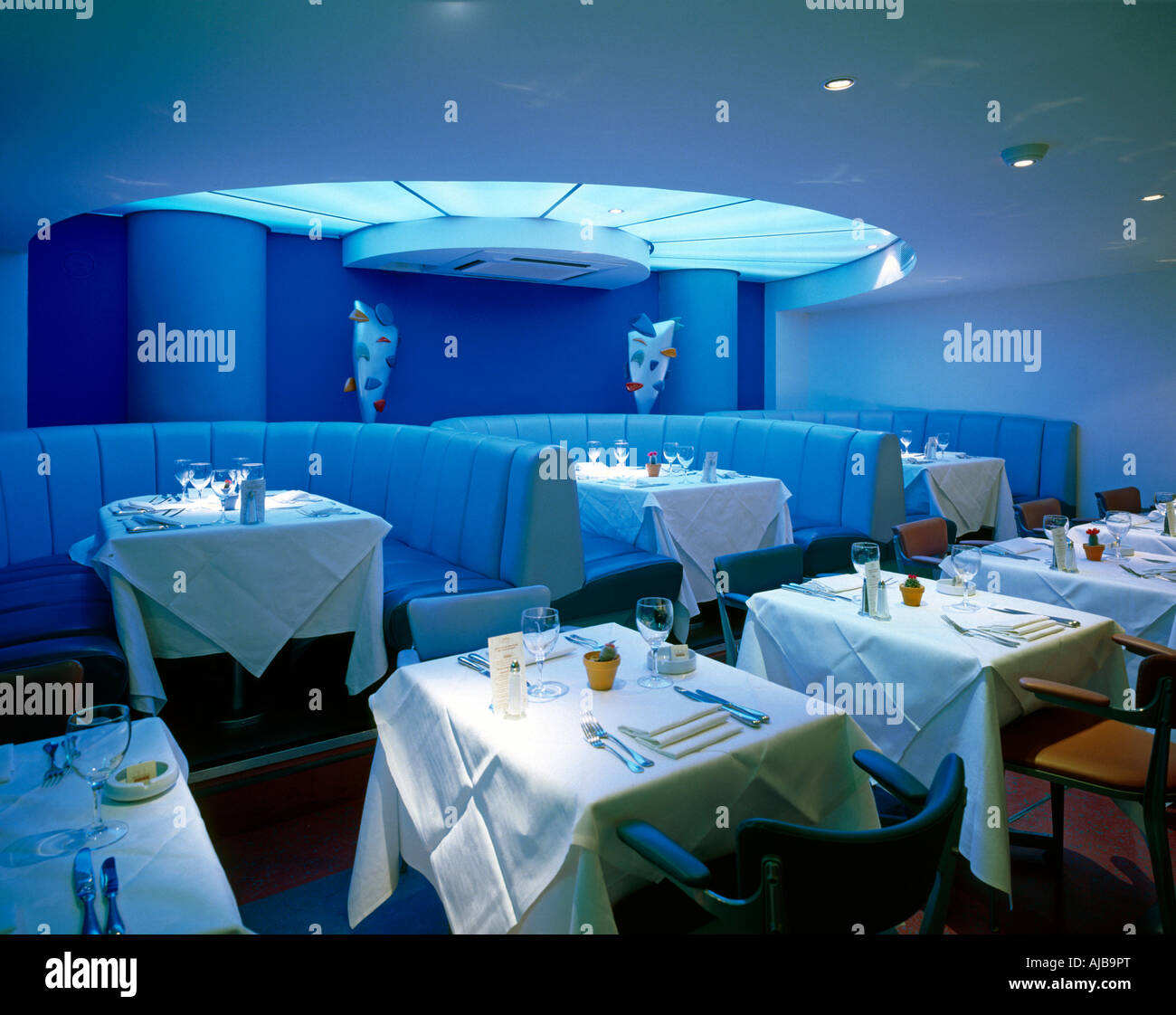 Interior of restaurant bar with blue lighting laid dinner tables HXXZsm ...