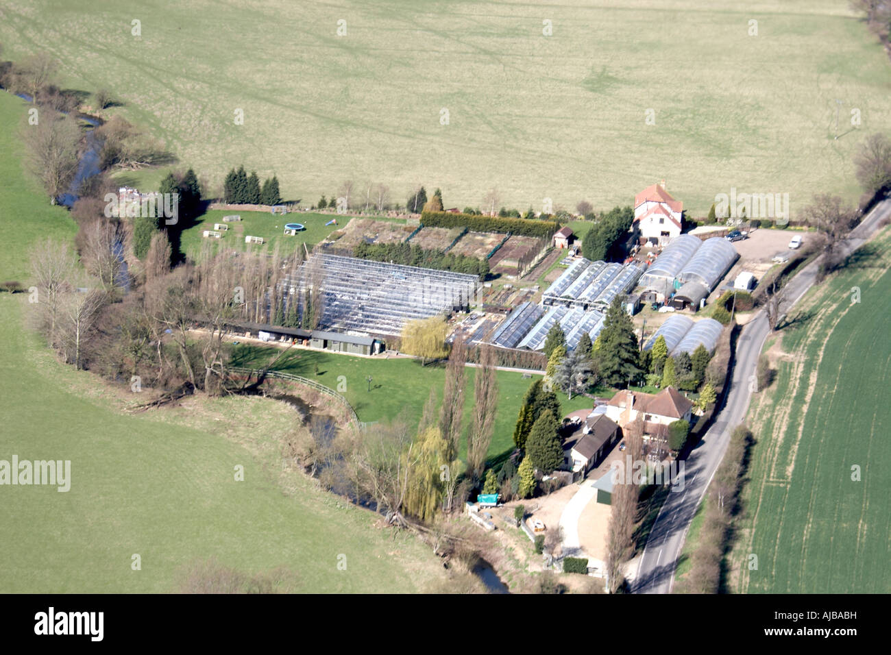 Aerial view west of farm or garden centre with river in rural ...