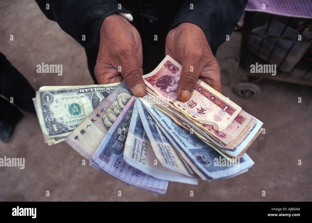 Fistful of banknotes to trade Uyghur money changer on the streets of ...