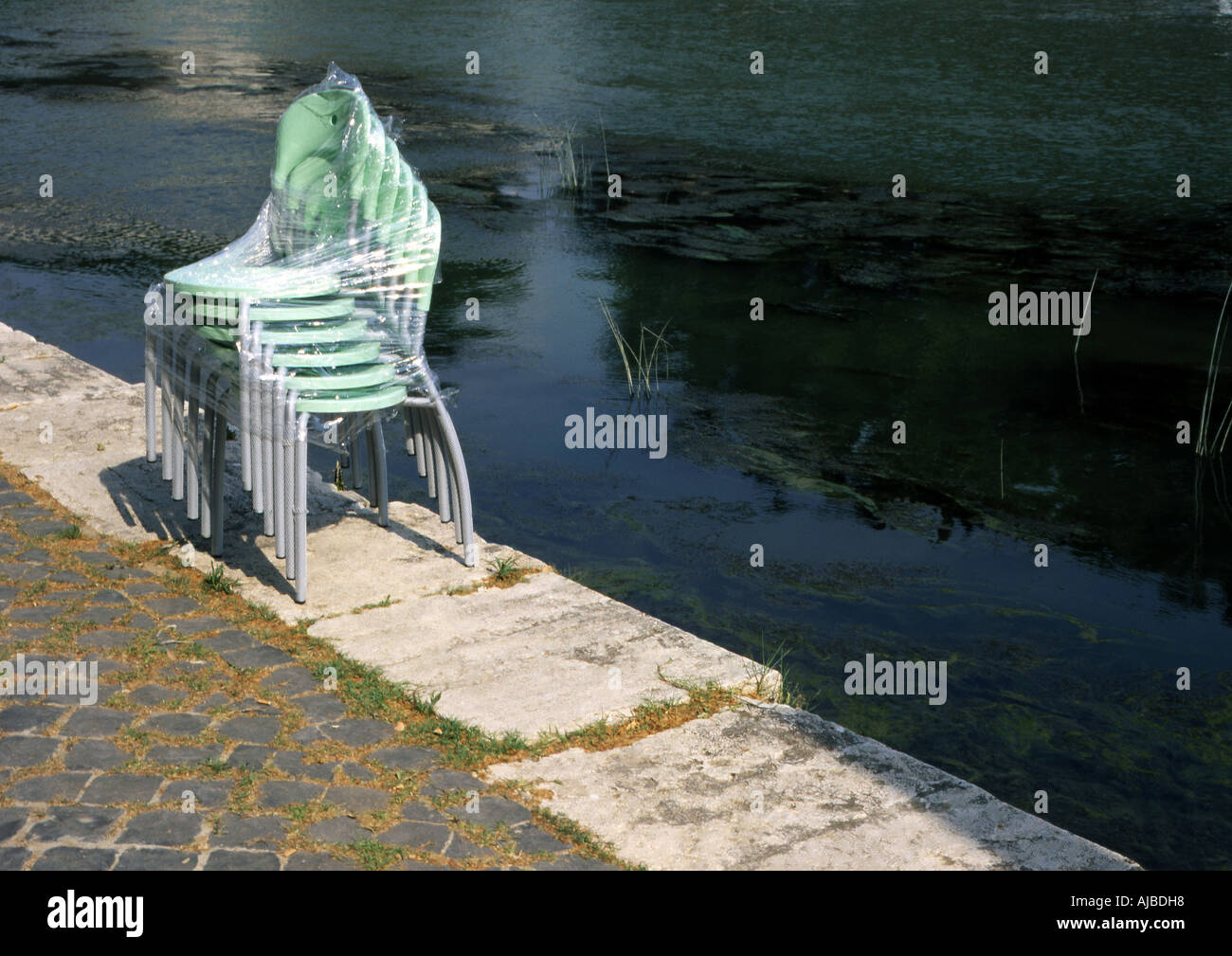 stack of brand new chairs by river bank Stock Photo - Alamy